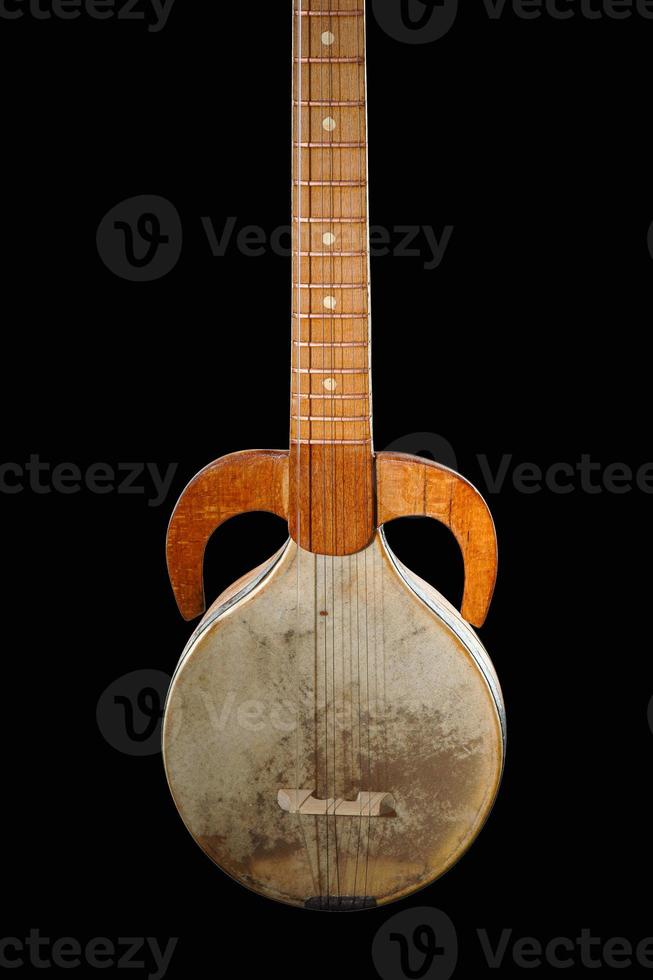 An ancient Asian stringed musical instrument on a black background ...