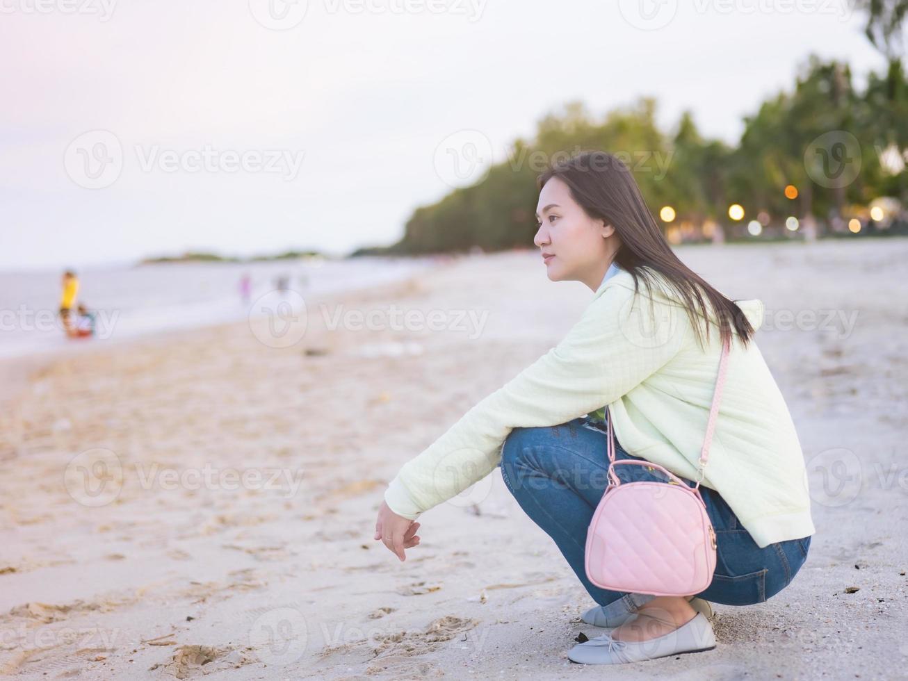 mujeres asiáticas que viajan al mar sentadas en la playa mirando a su alrededor. lanzamiento de ...