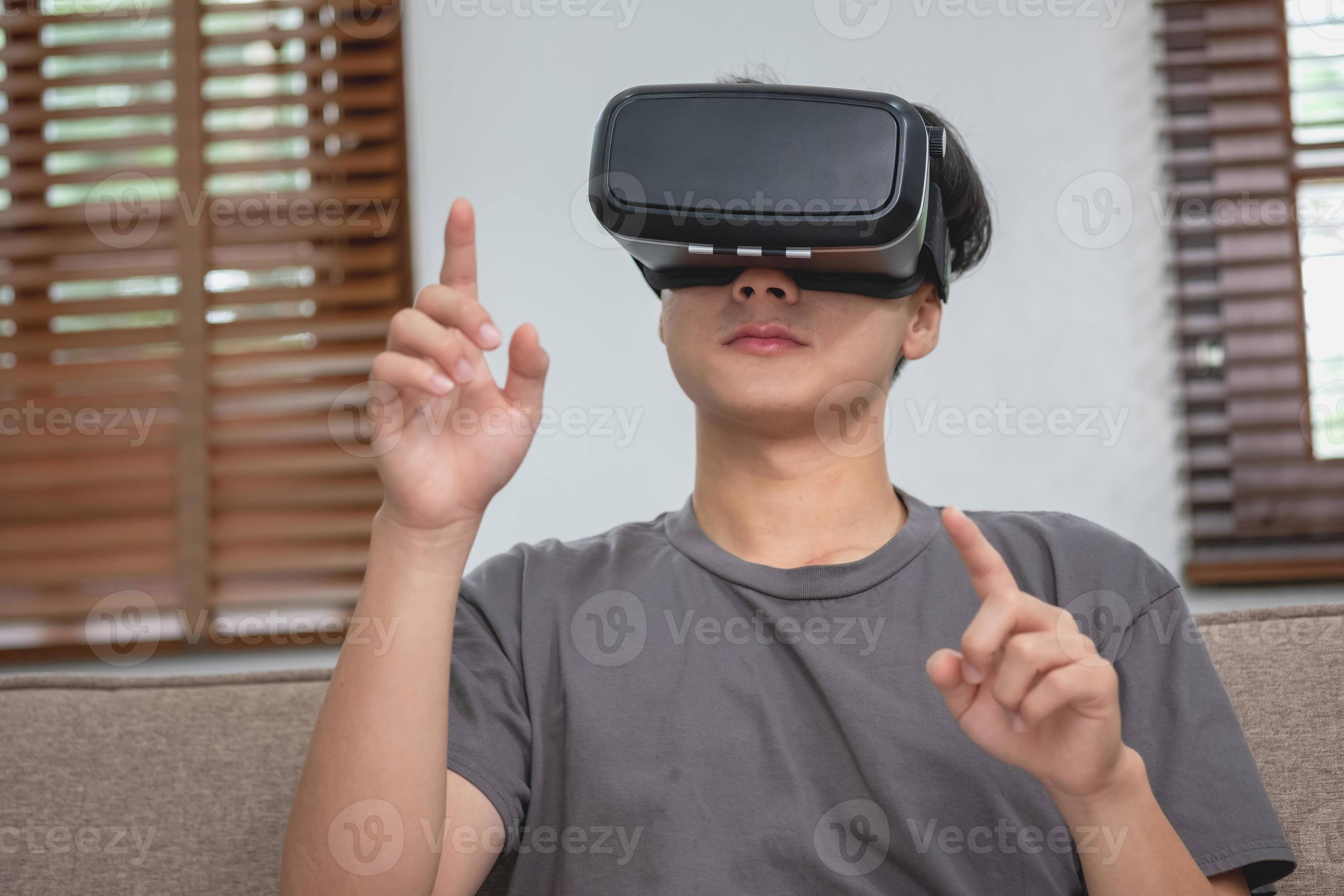 relieve stress on vacation Happy Asian white man relaxing at home playing VR 3D virtual reality ...