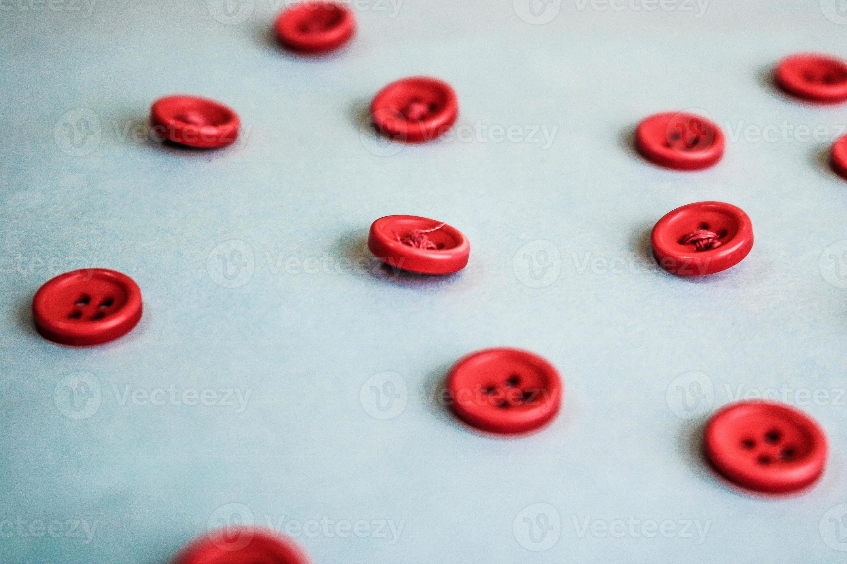 Beautiful texture with many round red buttons for sewing, needlework. Copy space. Flat lay. Blue ...