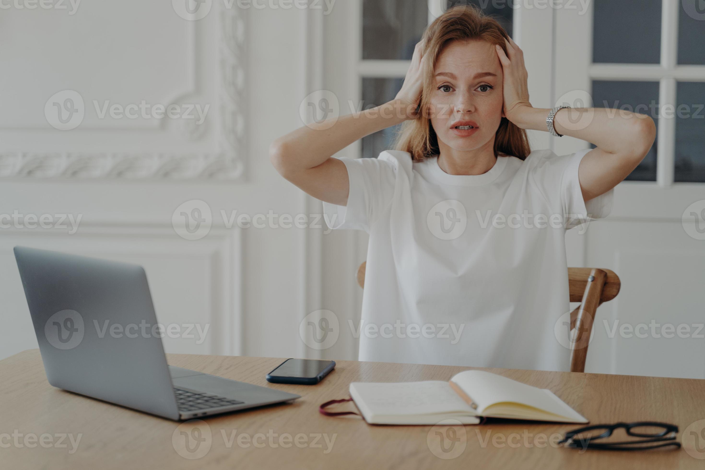 mujer estresada sosteniendo la cabeza en las manos, pensando en resolver problemas, sentada en ...