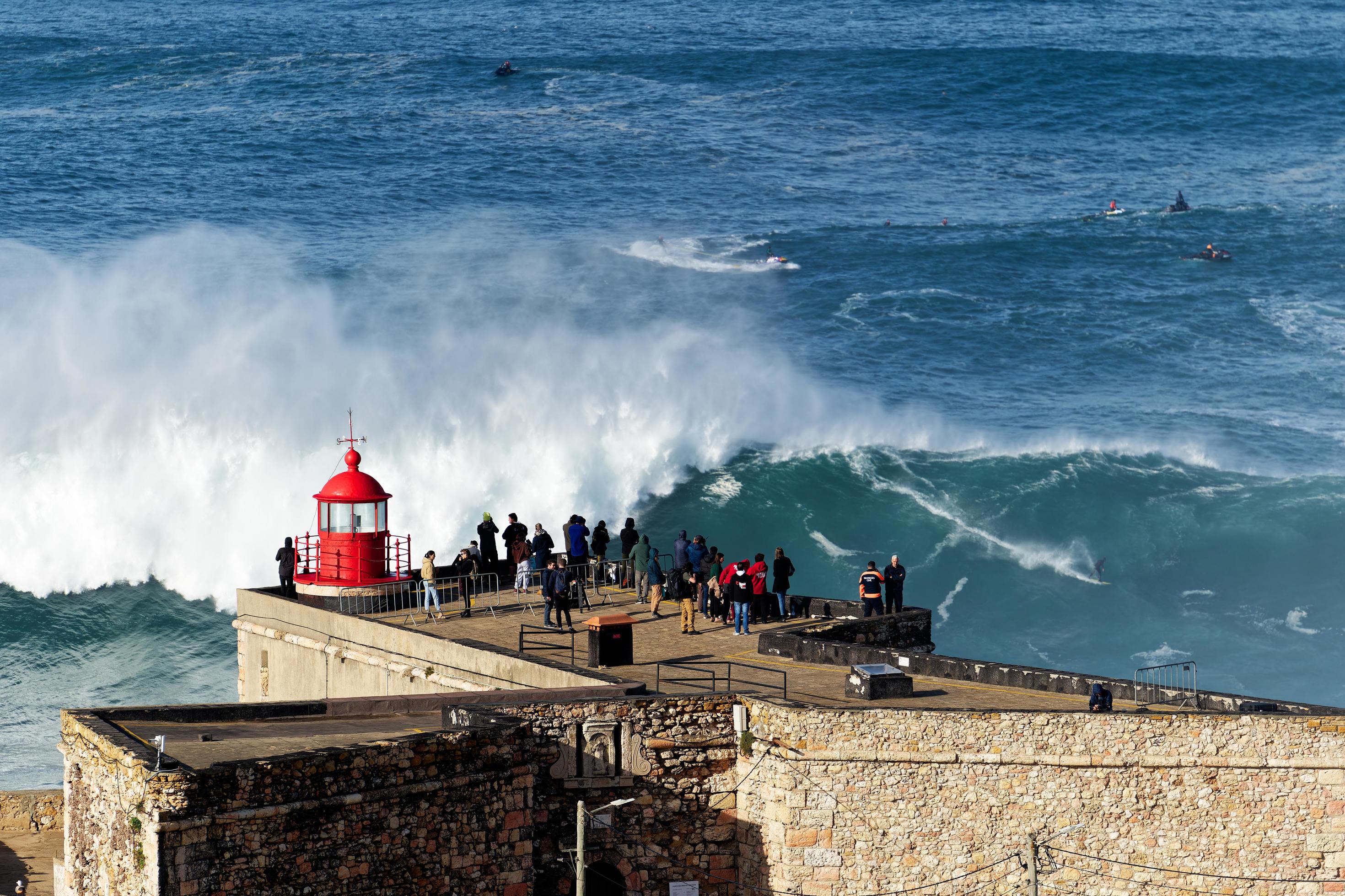 nazare, portugal - 7 de noviembre de 2022 personas viendo a un surfista montando una ola gigante ...