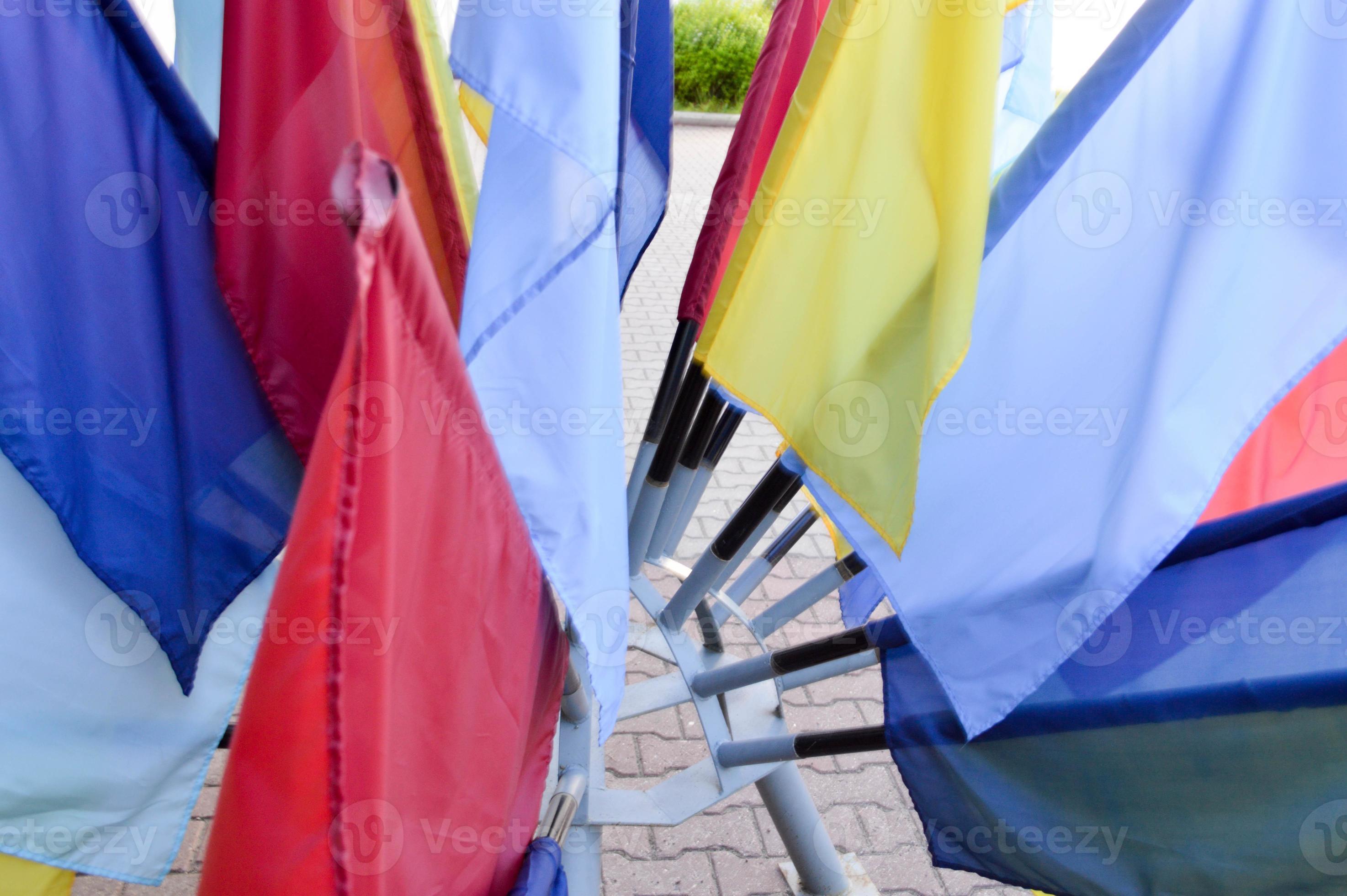 Texture of multi-colored festive red, blue, yellow flags made of fabric ...