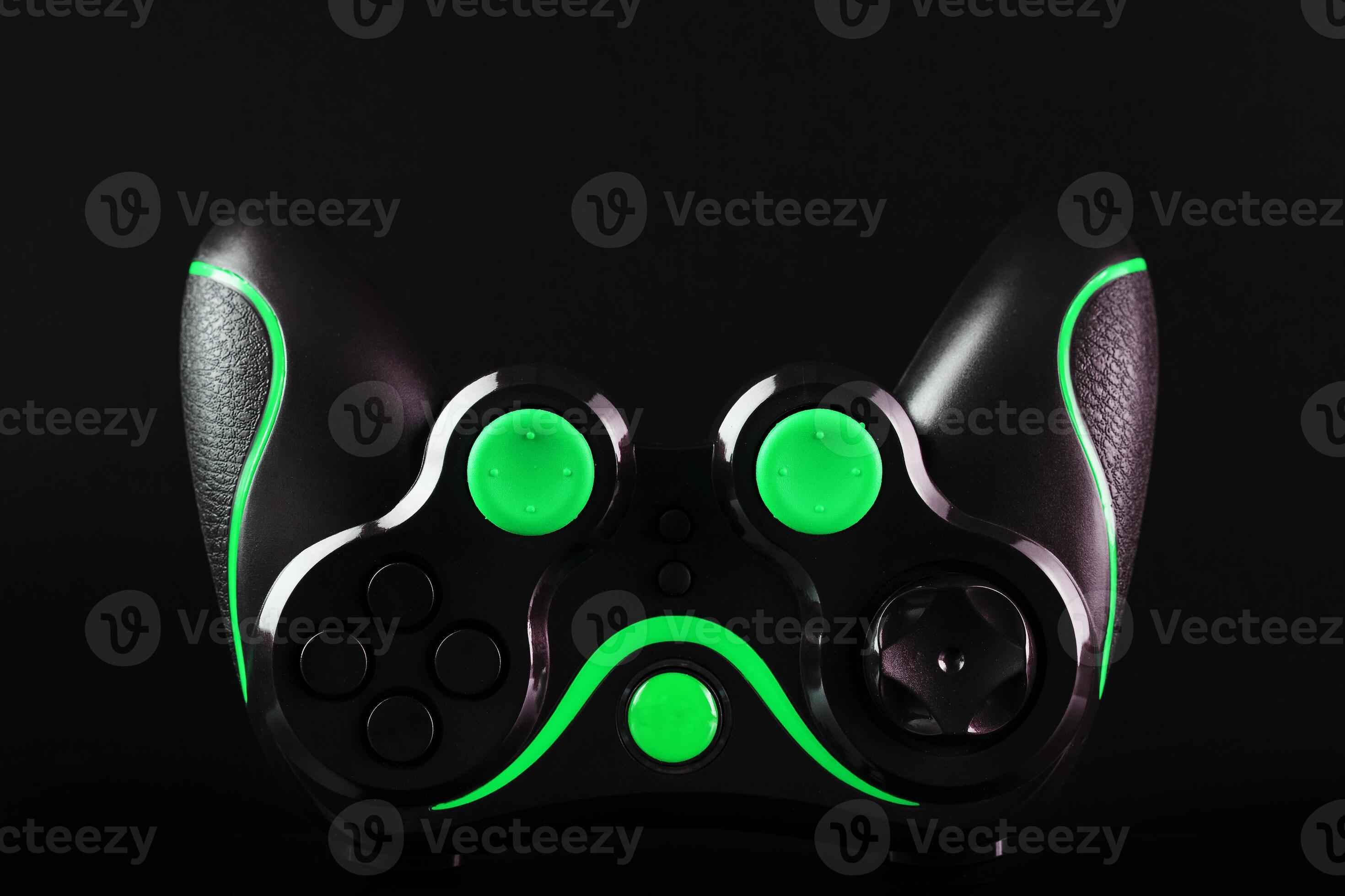 Black game controller gamepad with green buttons on black background ...