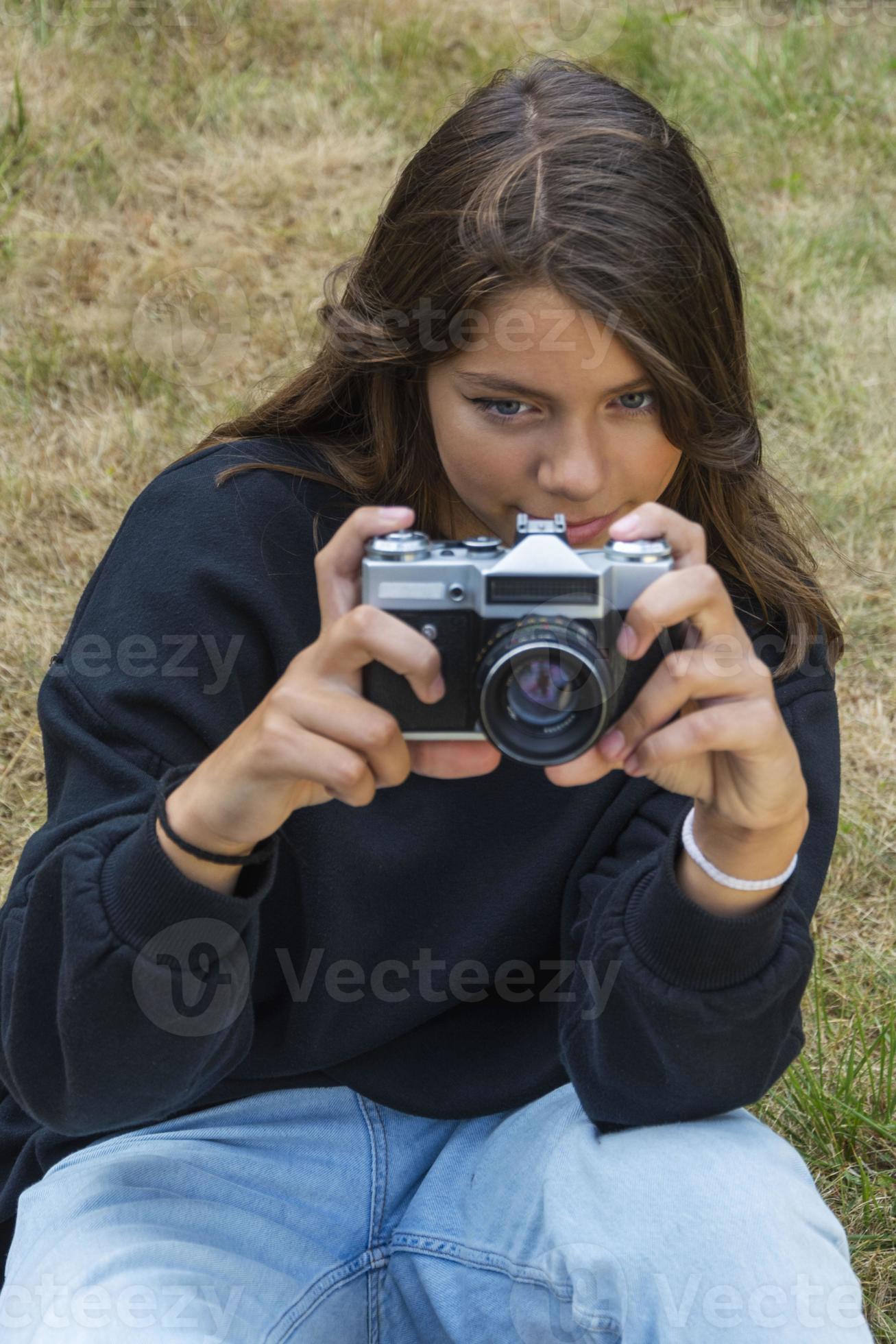 Cute teen girl with a camera, a girl taking pictures on a retro vintage ...