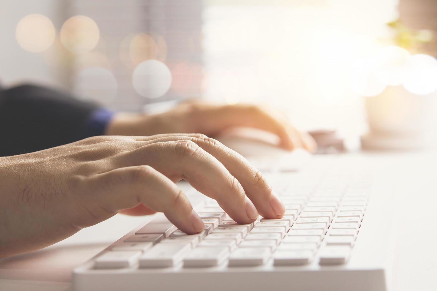 side view man hands typing computer keyboard White laptop on desk with ... side view man hands typing computer keyboard White laptop on desk with ...