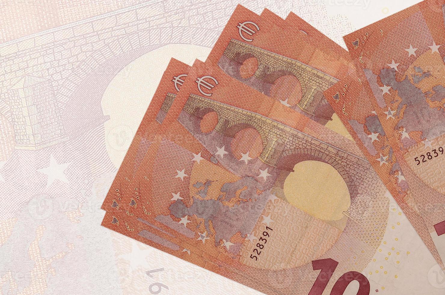 10 euro bills lies in stack on background of big semi-transparent banknote. Abstract ...