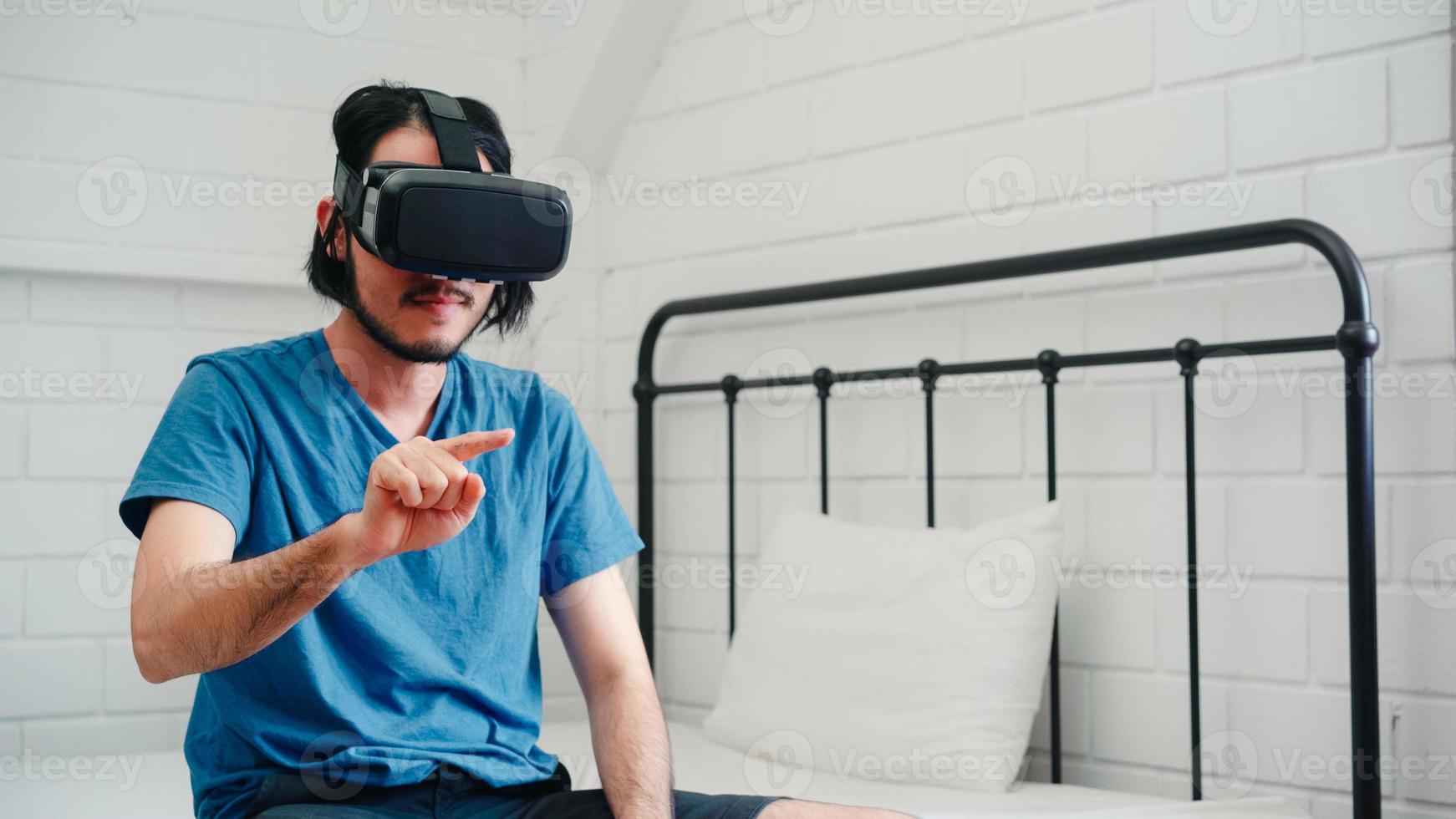 joven asiático usando anteojos simulador de realidad virtual jugando videojuegos en el ...