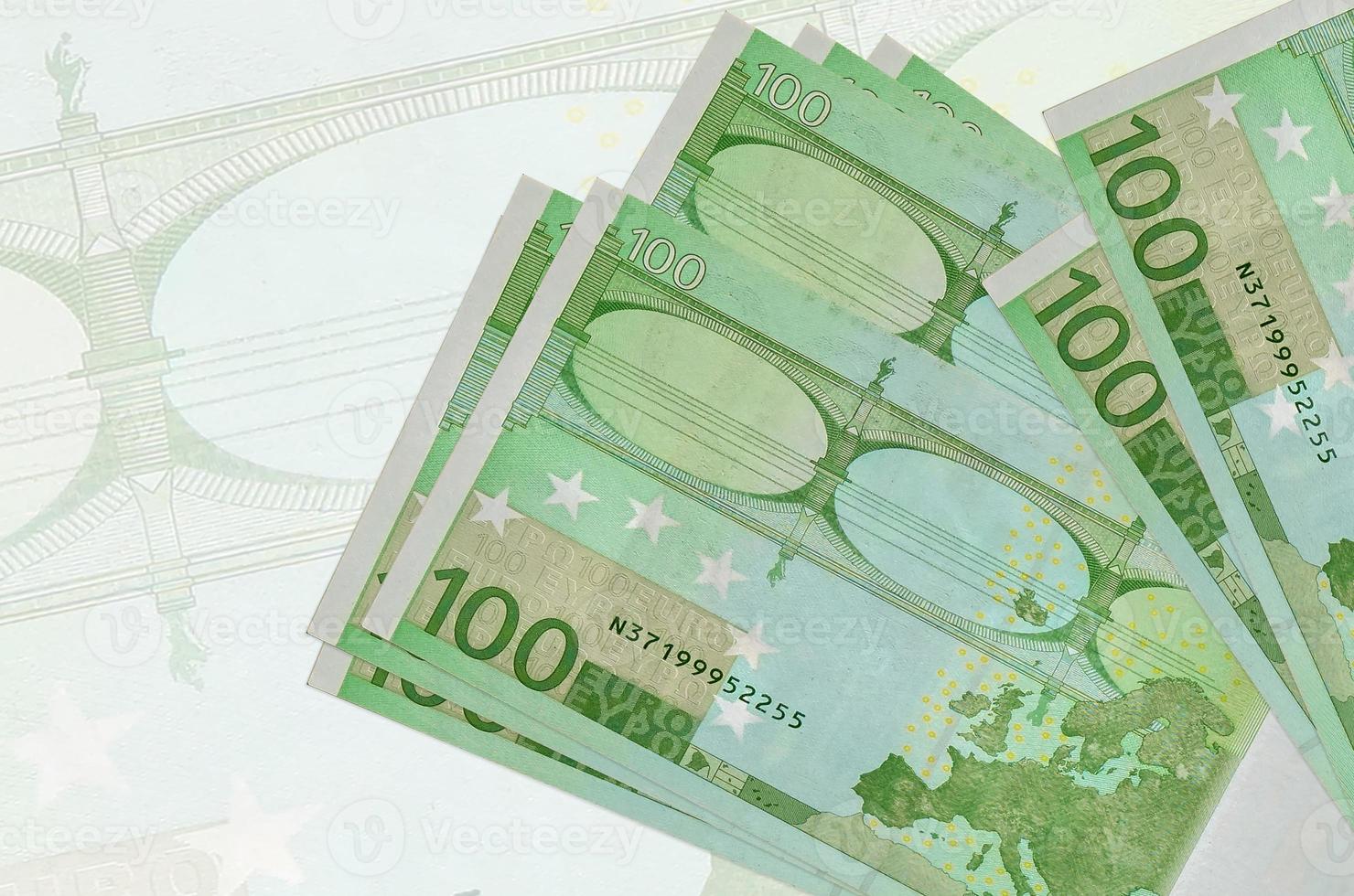 100 Euro bills lies in stack on background of big semi-transparent banknote. Abstract ...