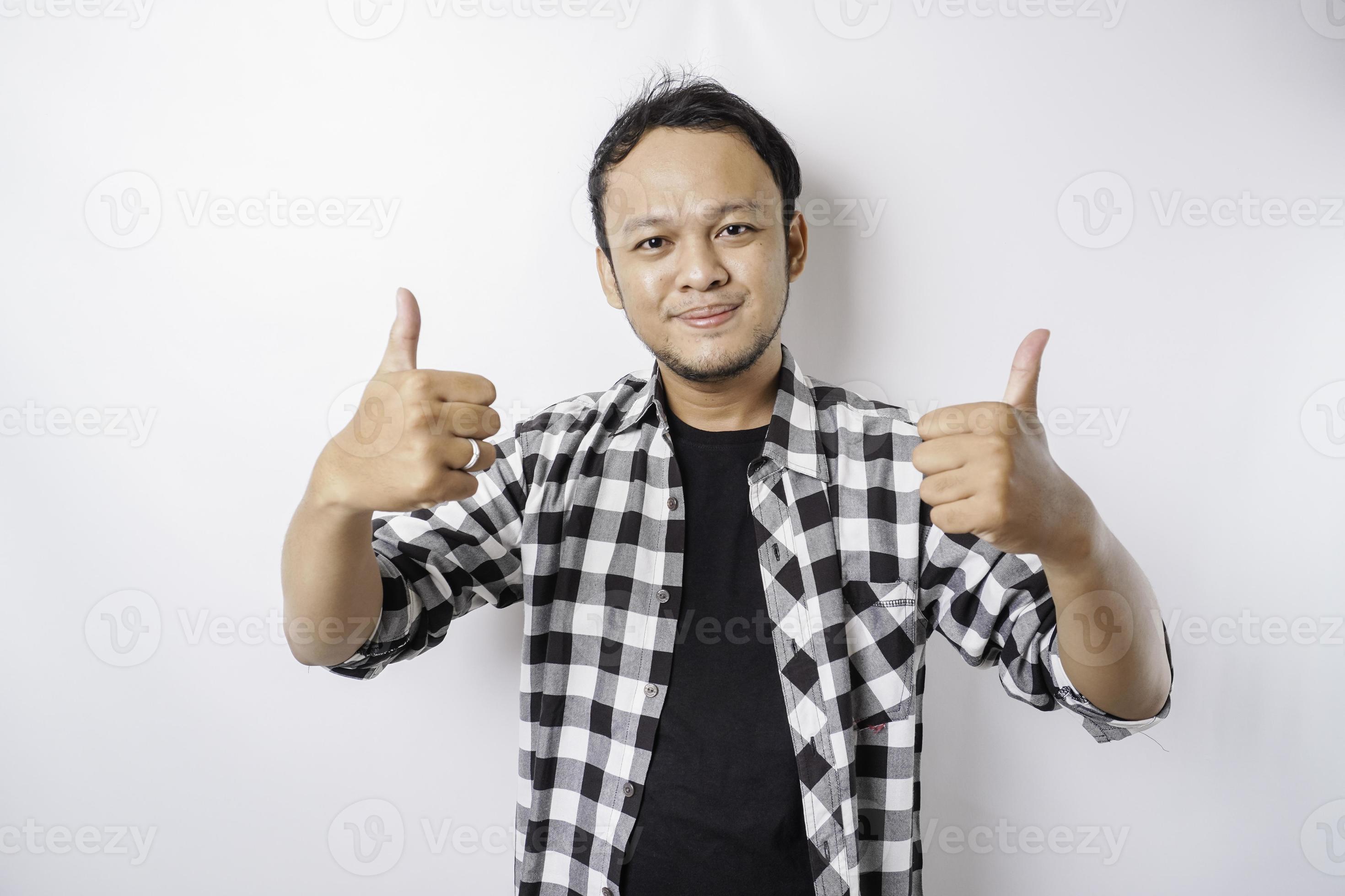 Excited Asian man wearing tartan shirt gives thumbs up hand gesture of ...