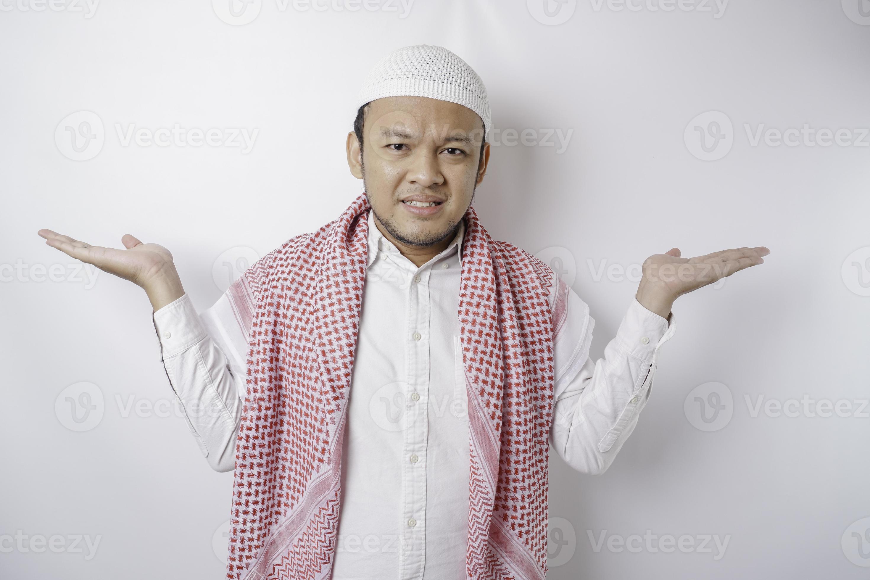 A thoughtful young Muslim man shrugging his shoulders, gesturing ...