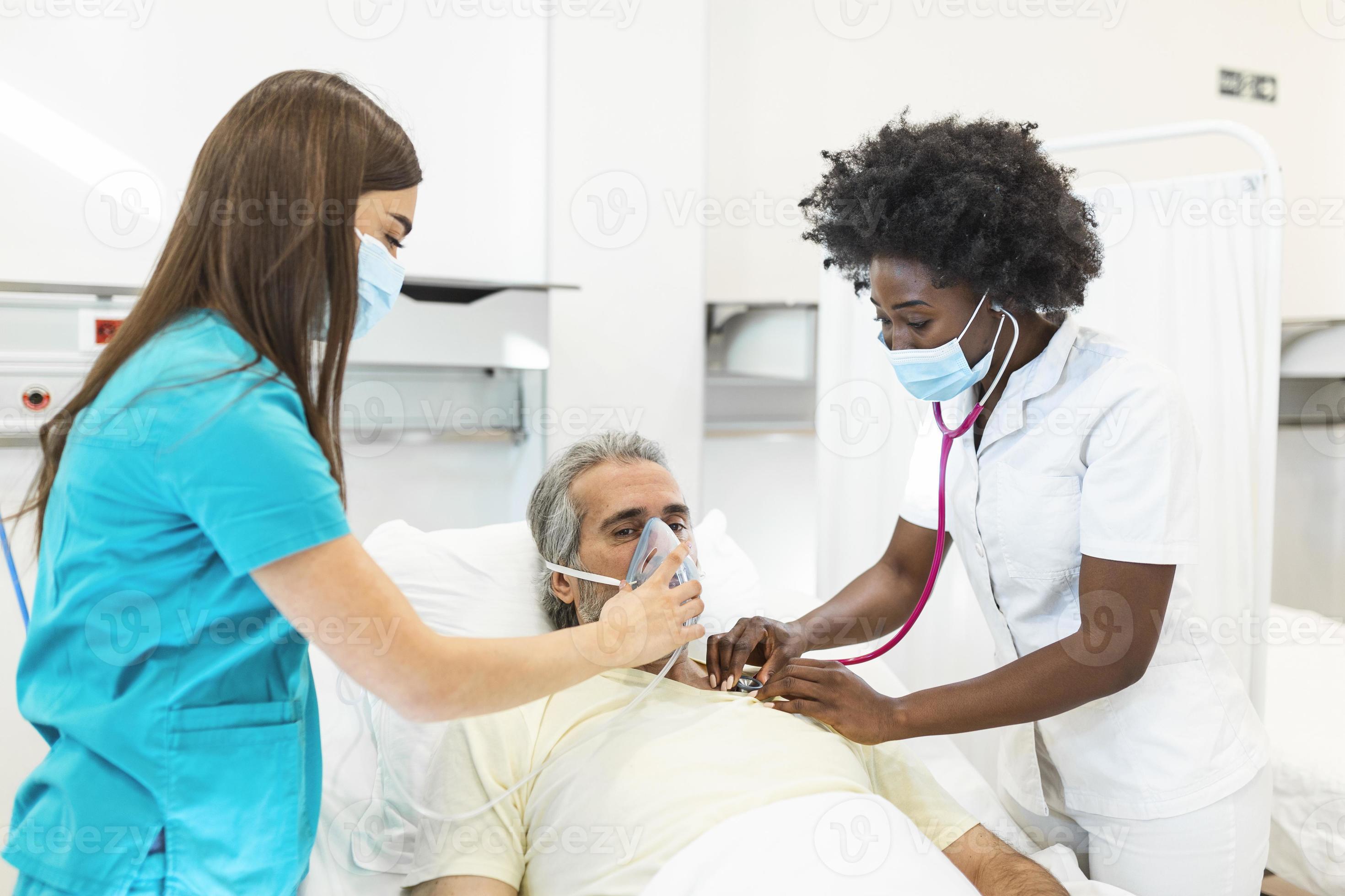 Nurse Puts Oxygen Mask On Elderly Man Patient Lying In The Hospital