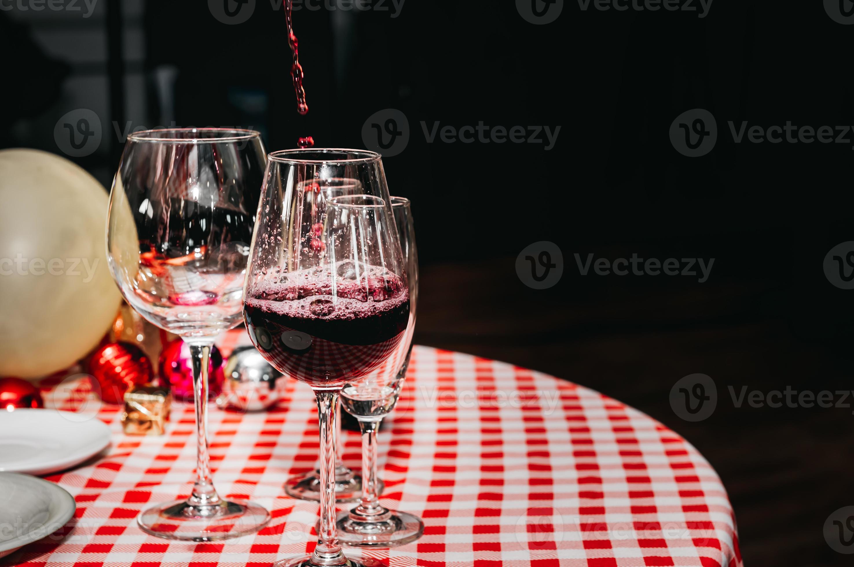Pouring Red Wine Into Glasses In Christmas Celebration Hands Holding The Glasses Of Champagne