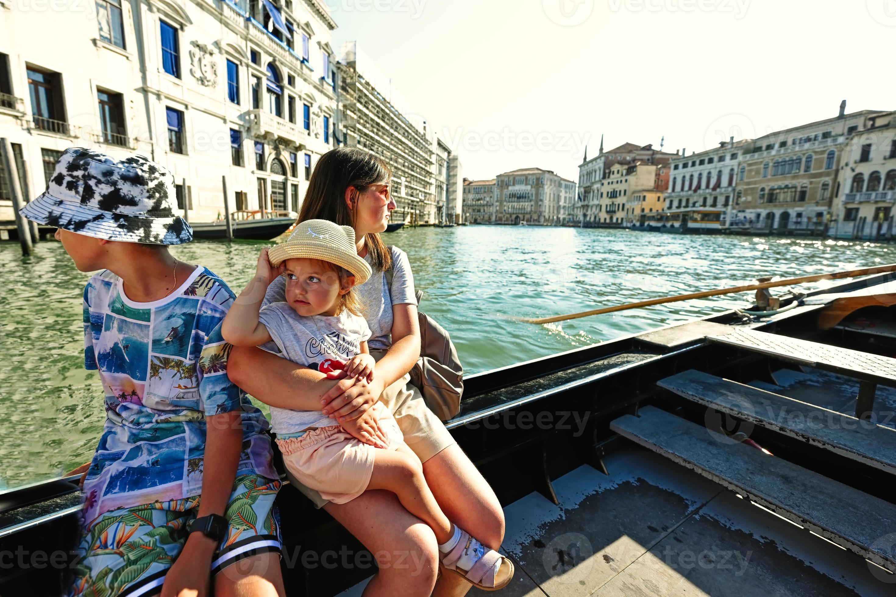 Mother with kids sit at gondola in Venice, Italy. 15179448 Stock Photo at Vecteezy
