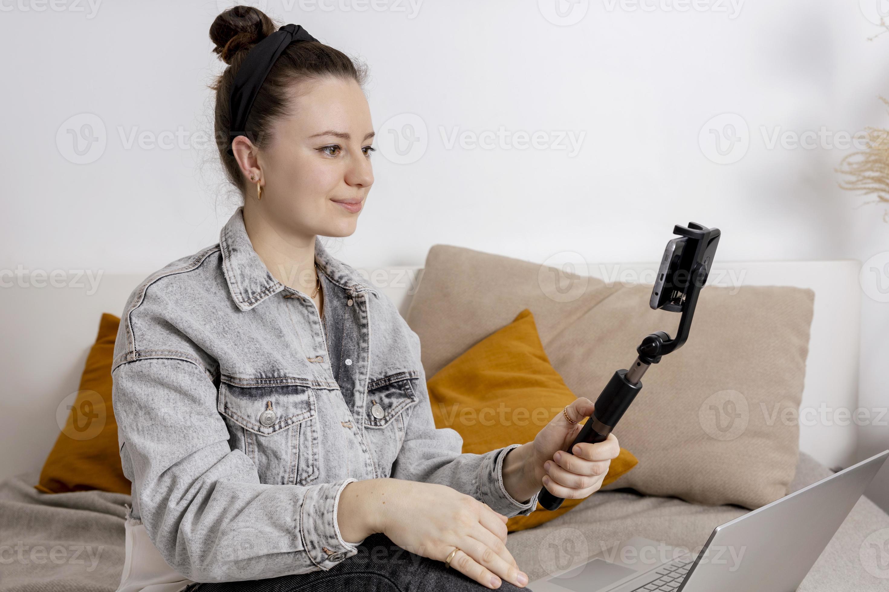 joven morena, bloguera, grabando blog de estilo de vida, hablando con la cámara del teléfono ...