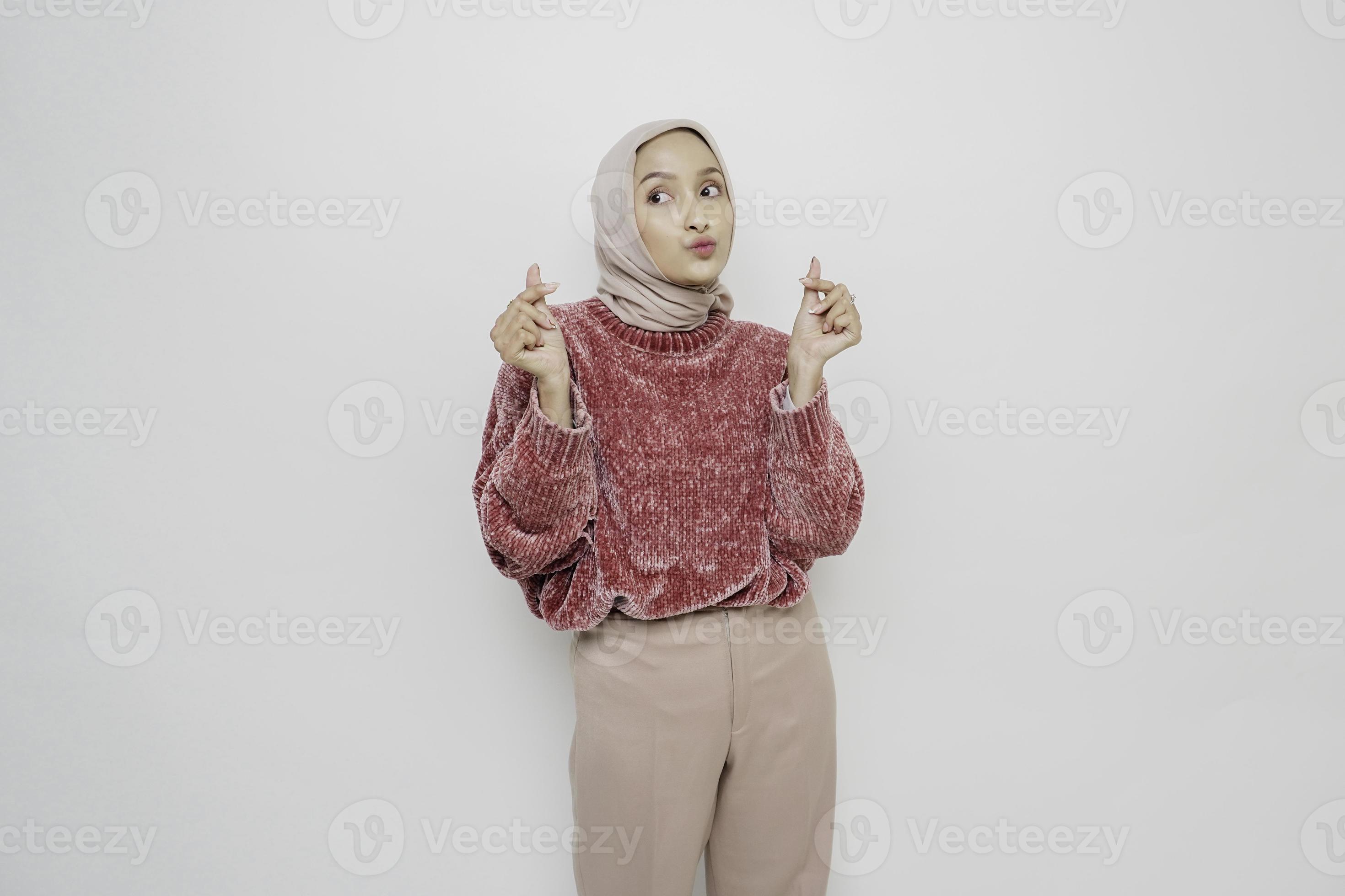 A Happy Young Asian Woman Wearing A Pink Sweater And Hijab Feels