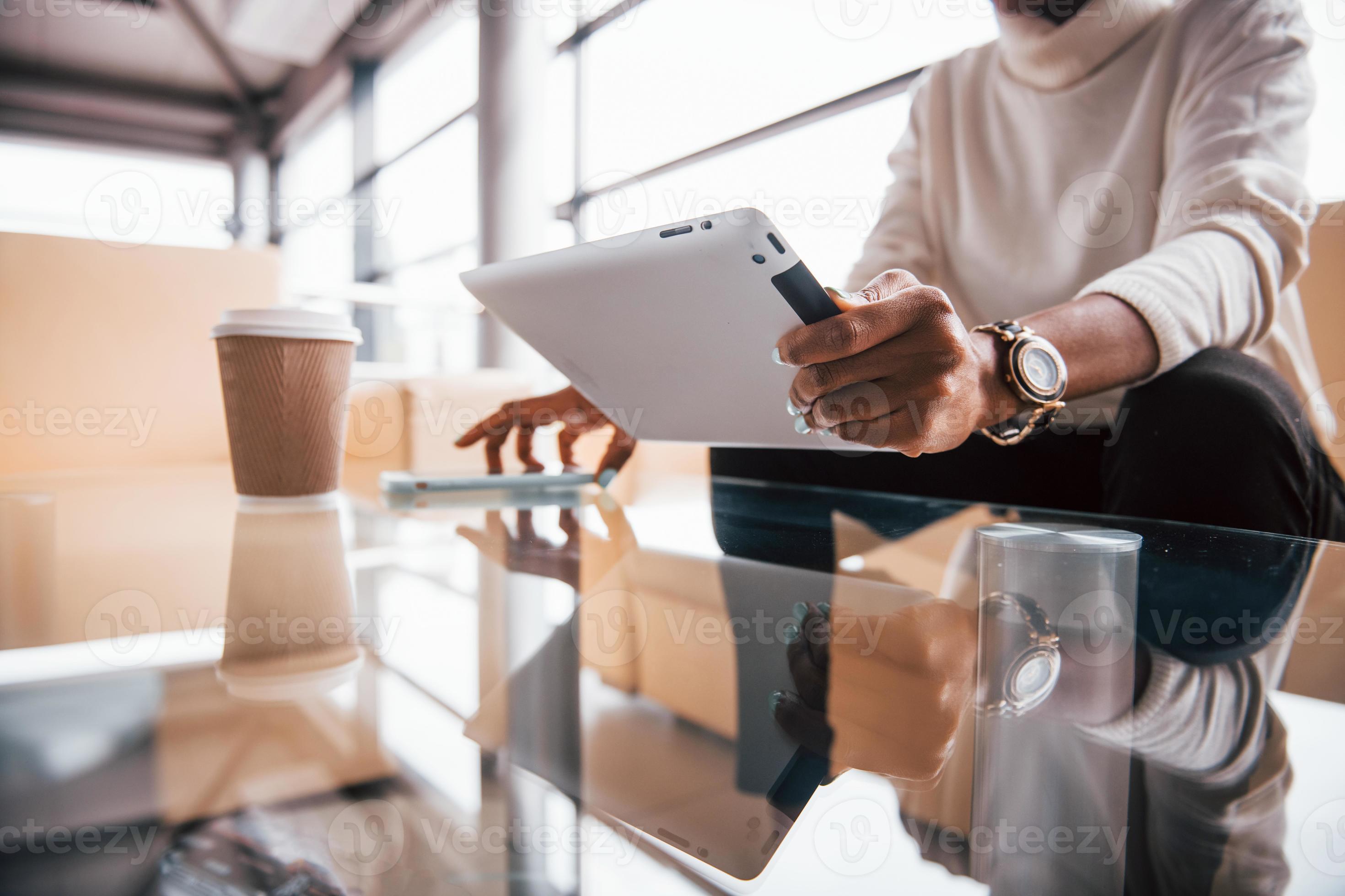 Young african american woman in glasses sits indoors in the office with ...
