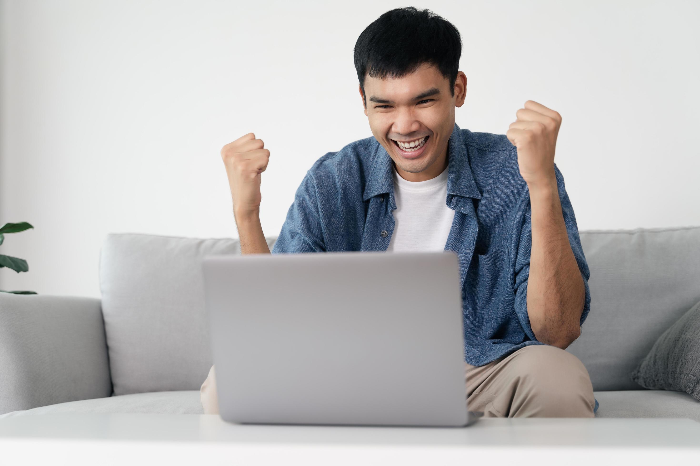 Happy excited Asian man looking at laptop, man receiving good news ... Happy excited Asian man looking at laptop, man receiving good news ...