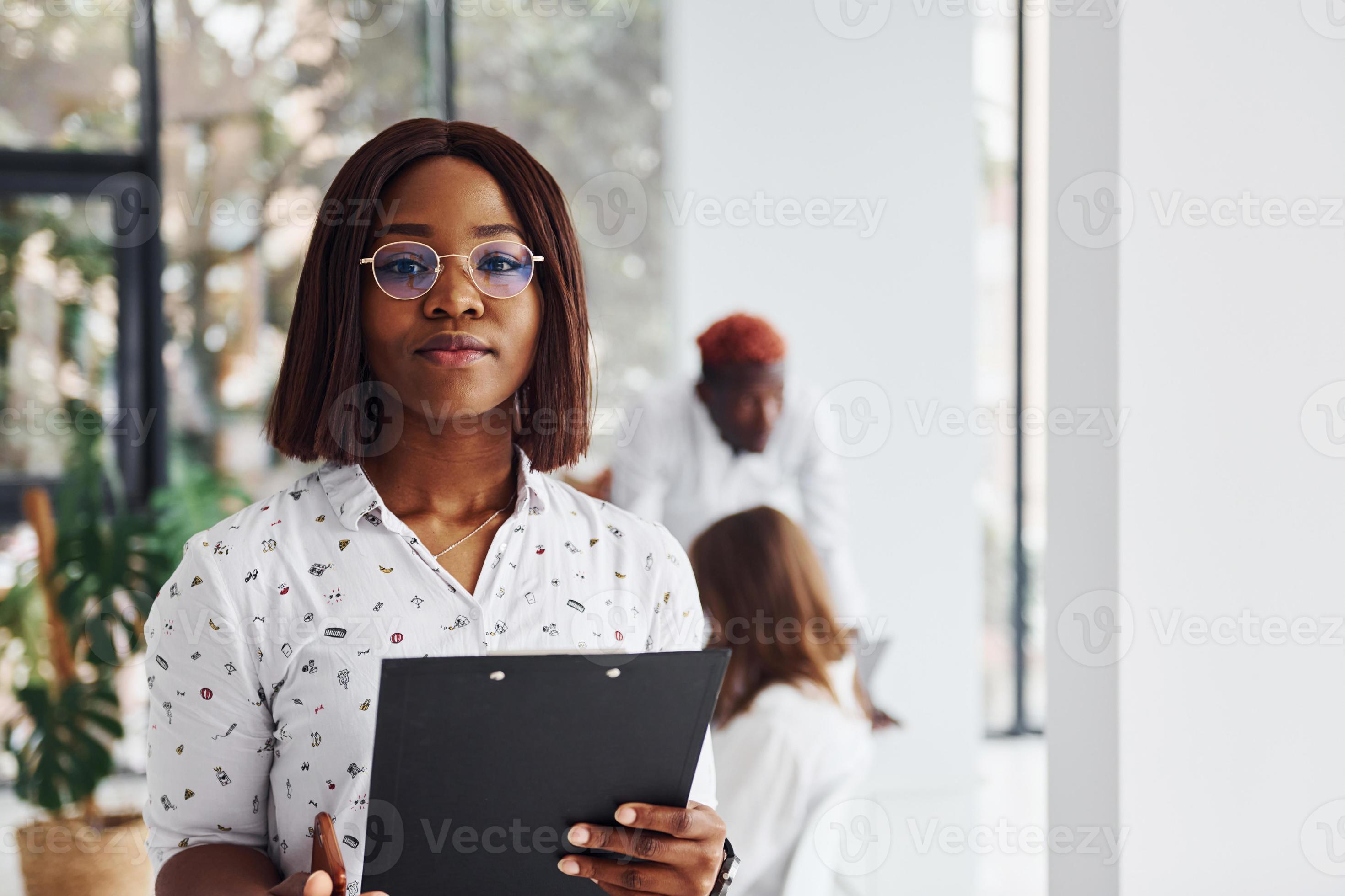 Beautiful woman in glasses in front of her colleagues. Group of african ...