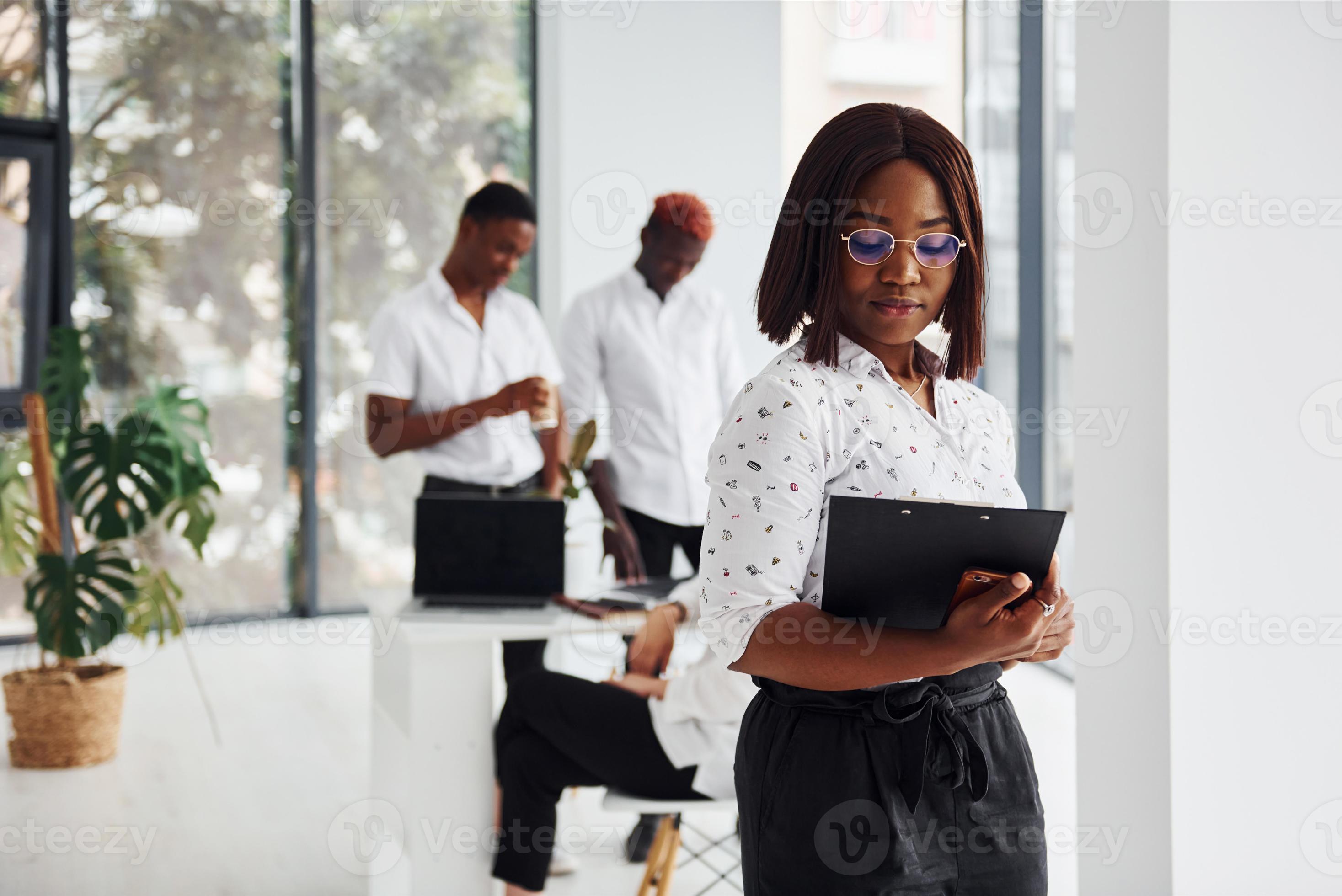 Beautiful woman in glasses in front of her colleagues. Group of african ...