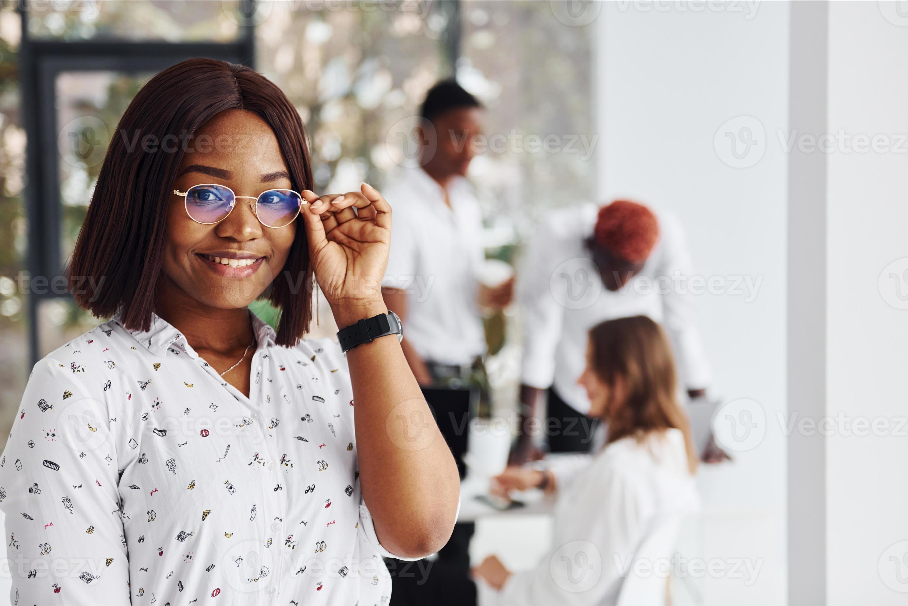 Beautiful woman in glasses in front of her colleagues. Group of african ...