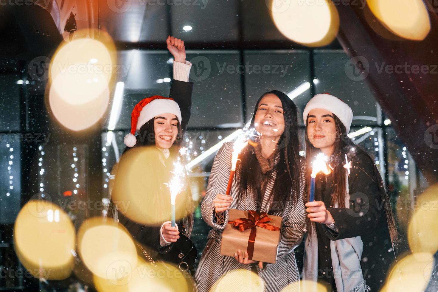 Little fireworks, Bengal lights. Three cheerful women spends Christmas holidays together ...