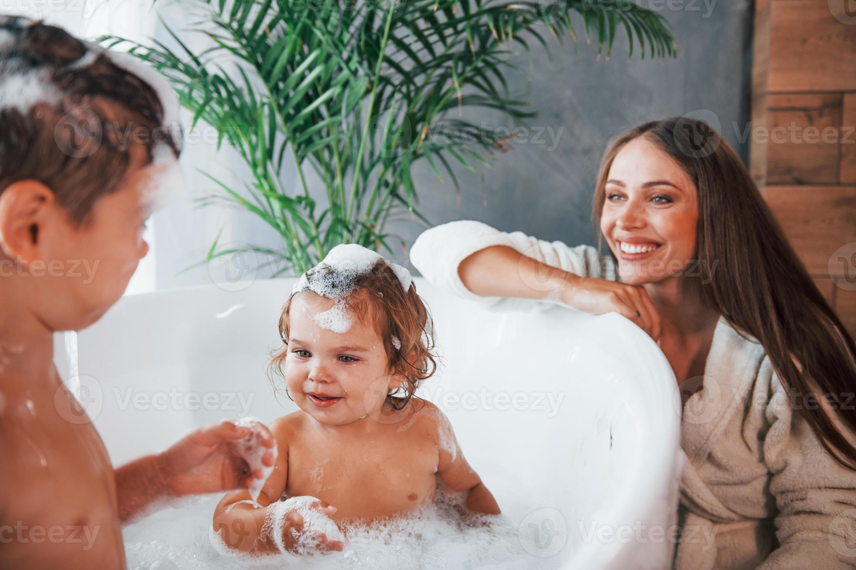 Having fun. Young mother helps her son and daughter. Two kids washing in the bath 15362918 Stock ...
