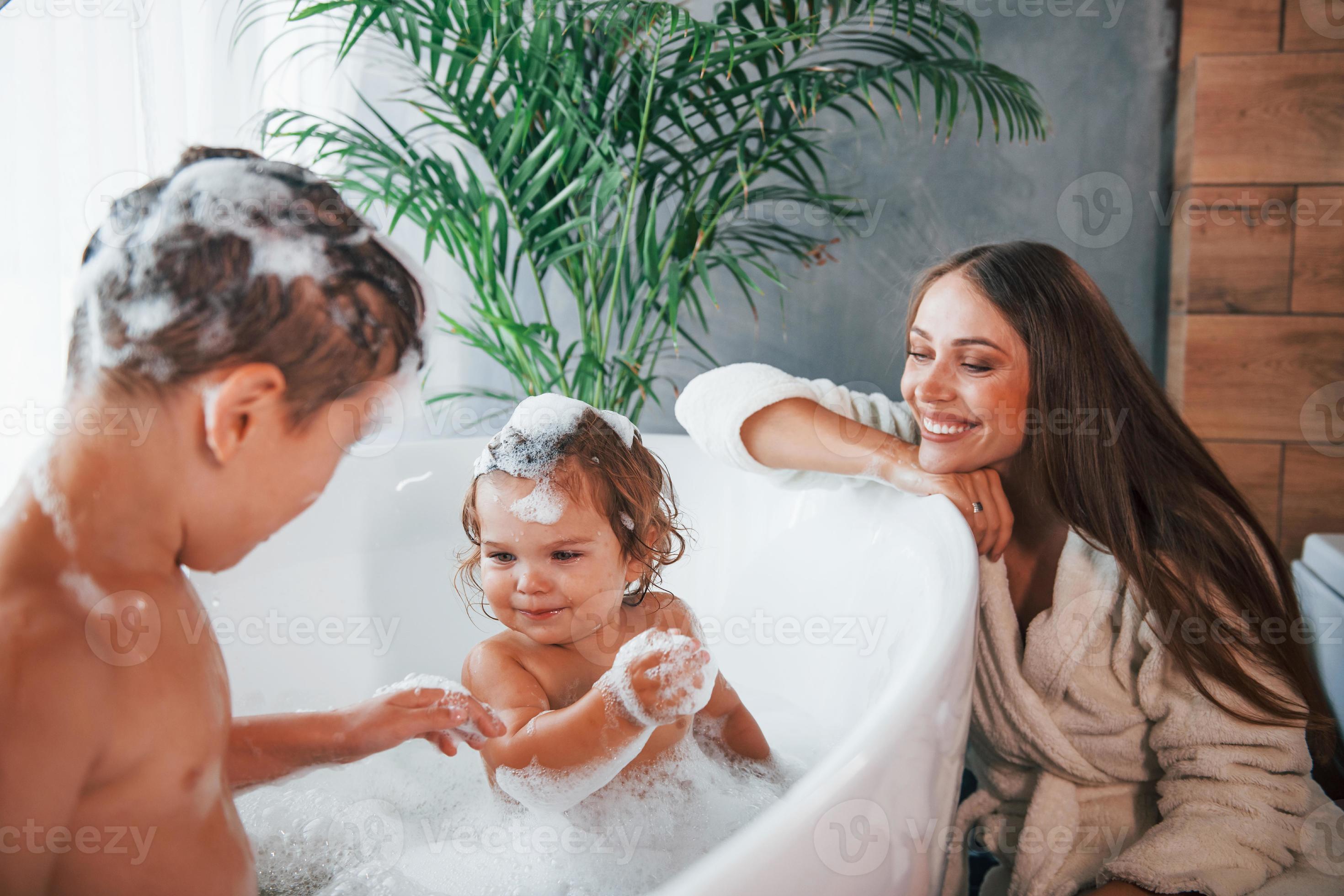 Having fun. Young mother helps her son and daughter. Two kids washing in the bath 15362926 Stock ...