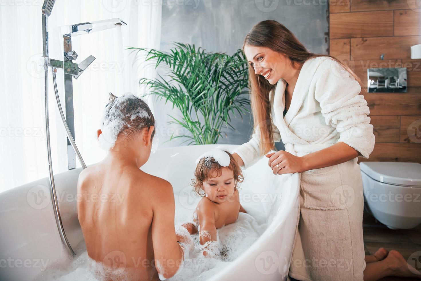 Having fun. Young mother helps her son and daughter. Two kids washing in the bath 15362934 Stock ...