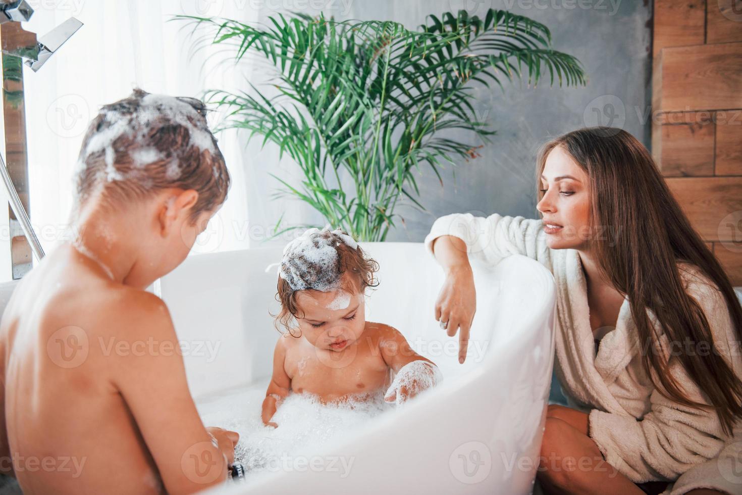 Having fun. Young mother helps her son and daughter. Two kids washing in the bath 15362980 Stock ...