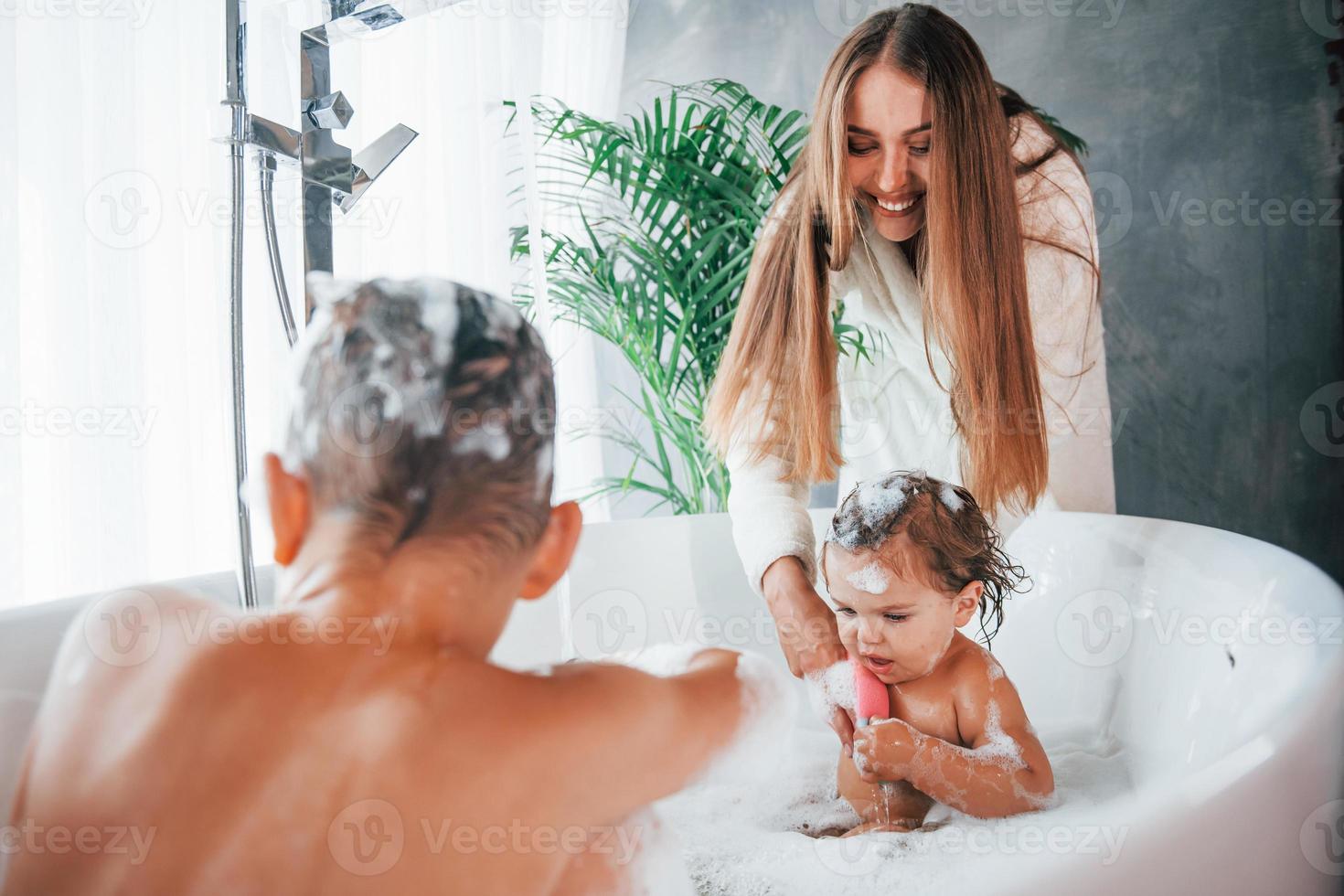 Having fun. Young mother helps her son and daughter. Two kids washing in the bath 15362999 Stock ...