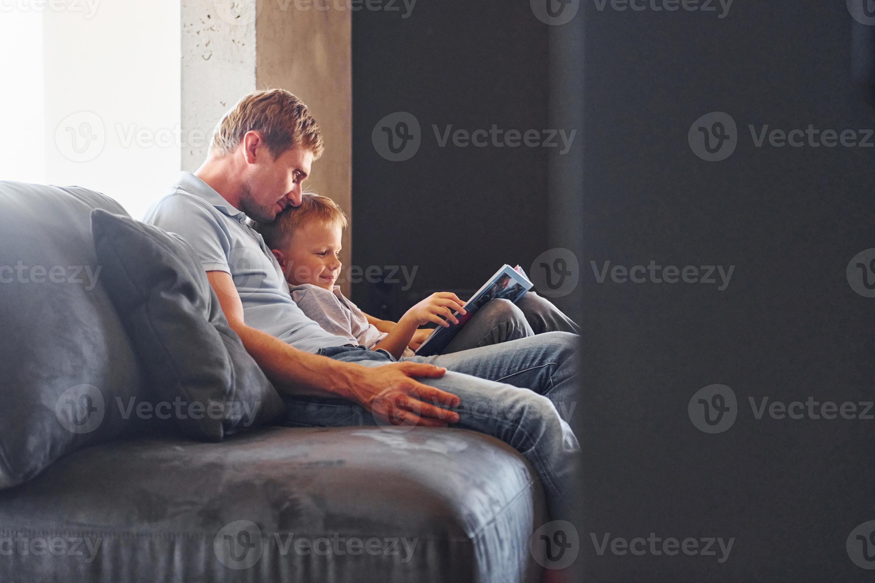 Sitting On The Sofa Father And Son Is Indoors At Home Together