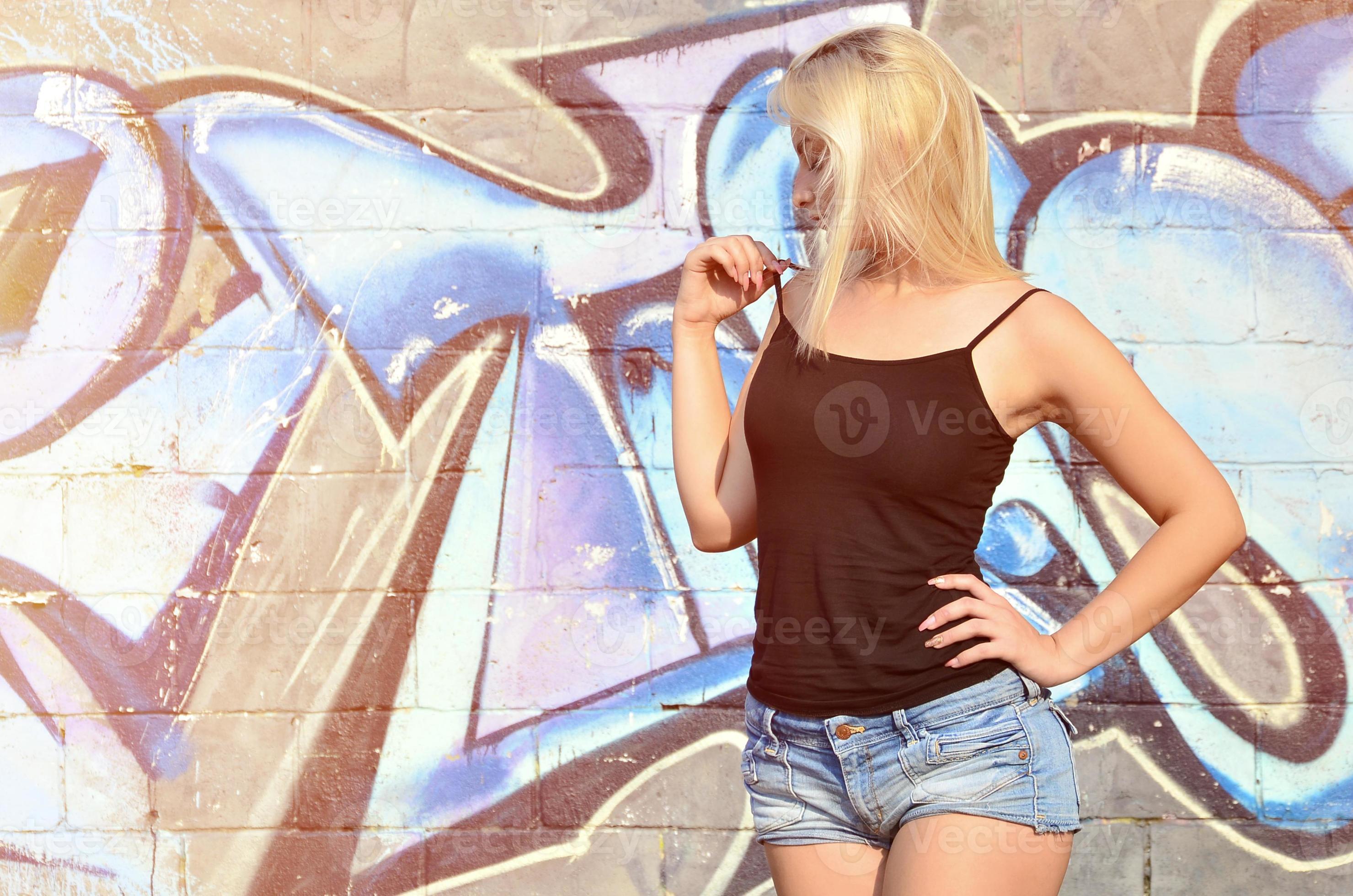 Sexy Caucasian Blonde Girl In Denim Shorts And Black Tank Top Posing