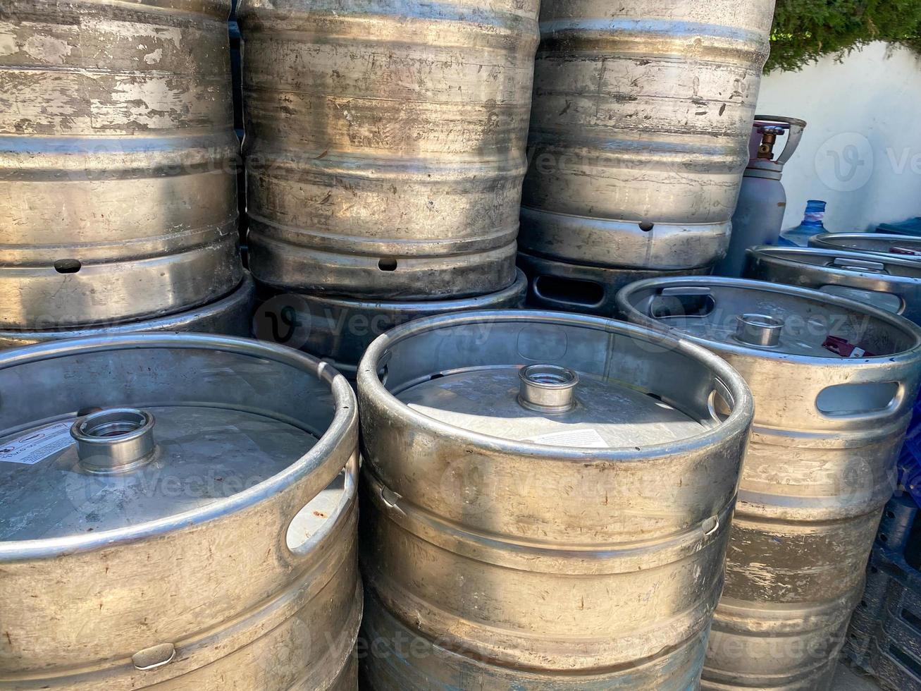 Old Aluminum Beer keg. Wall of used and scratched stainless steel beer barrels or kegs. Stacked ...