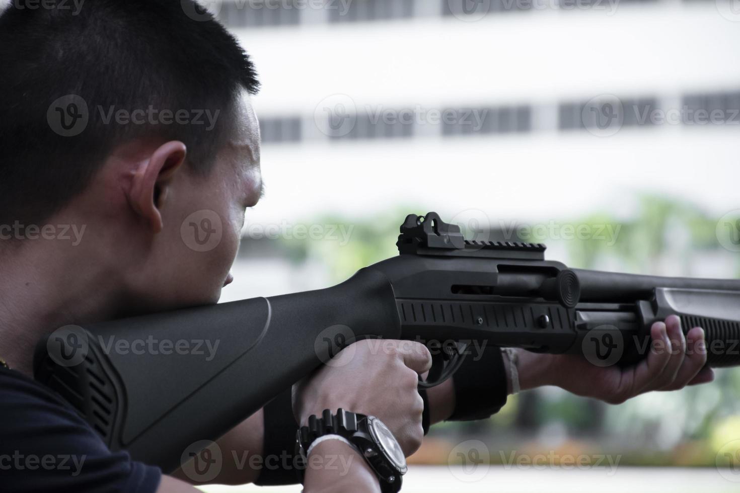 escopeta sosteniendo en las manos del tirador y mirando hacia el objetivo de tiro, enfoque suave ...