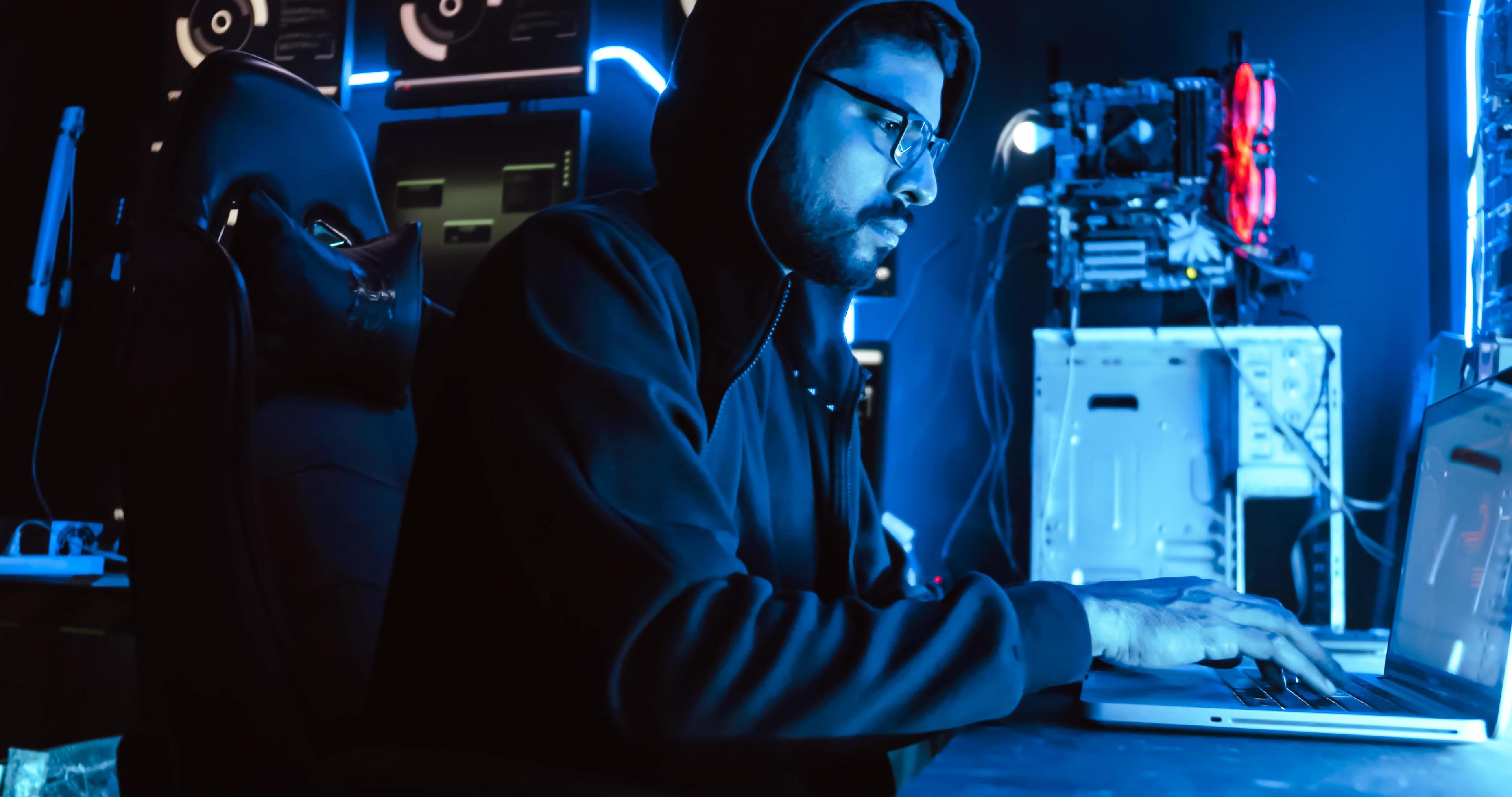 A male hacker is using a computer to hack data to demand ransom from ...