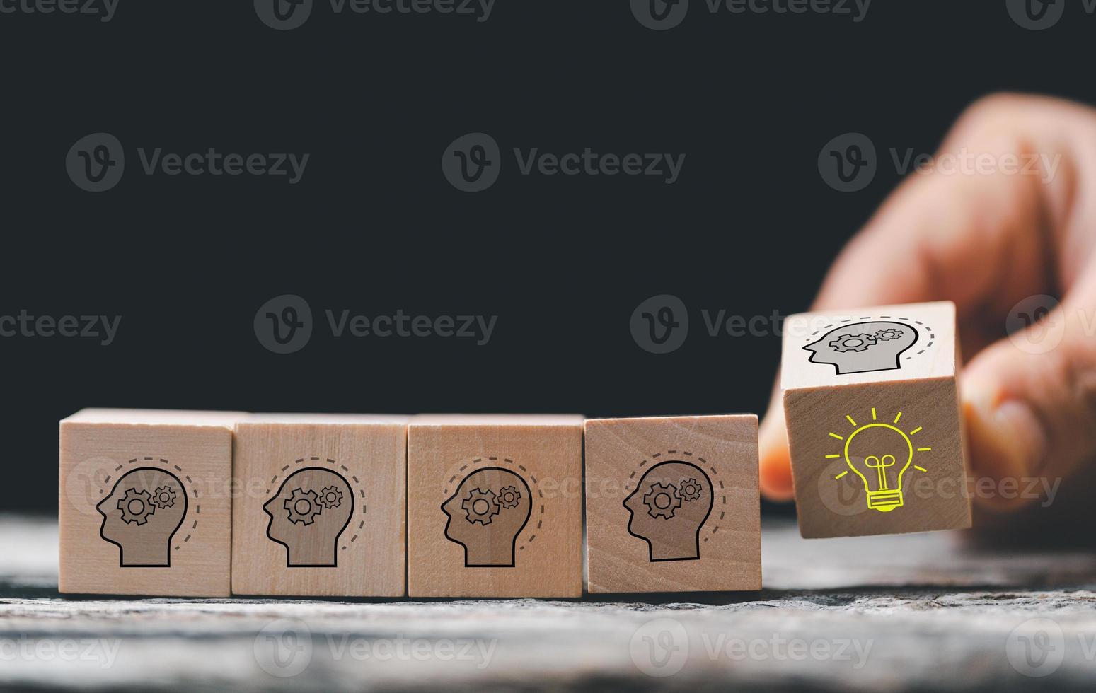 Concept creative idea and innovation. Hand choose wooden cube block with head human symbol and ...
