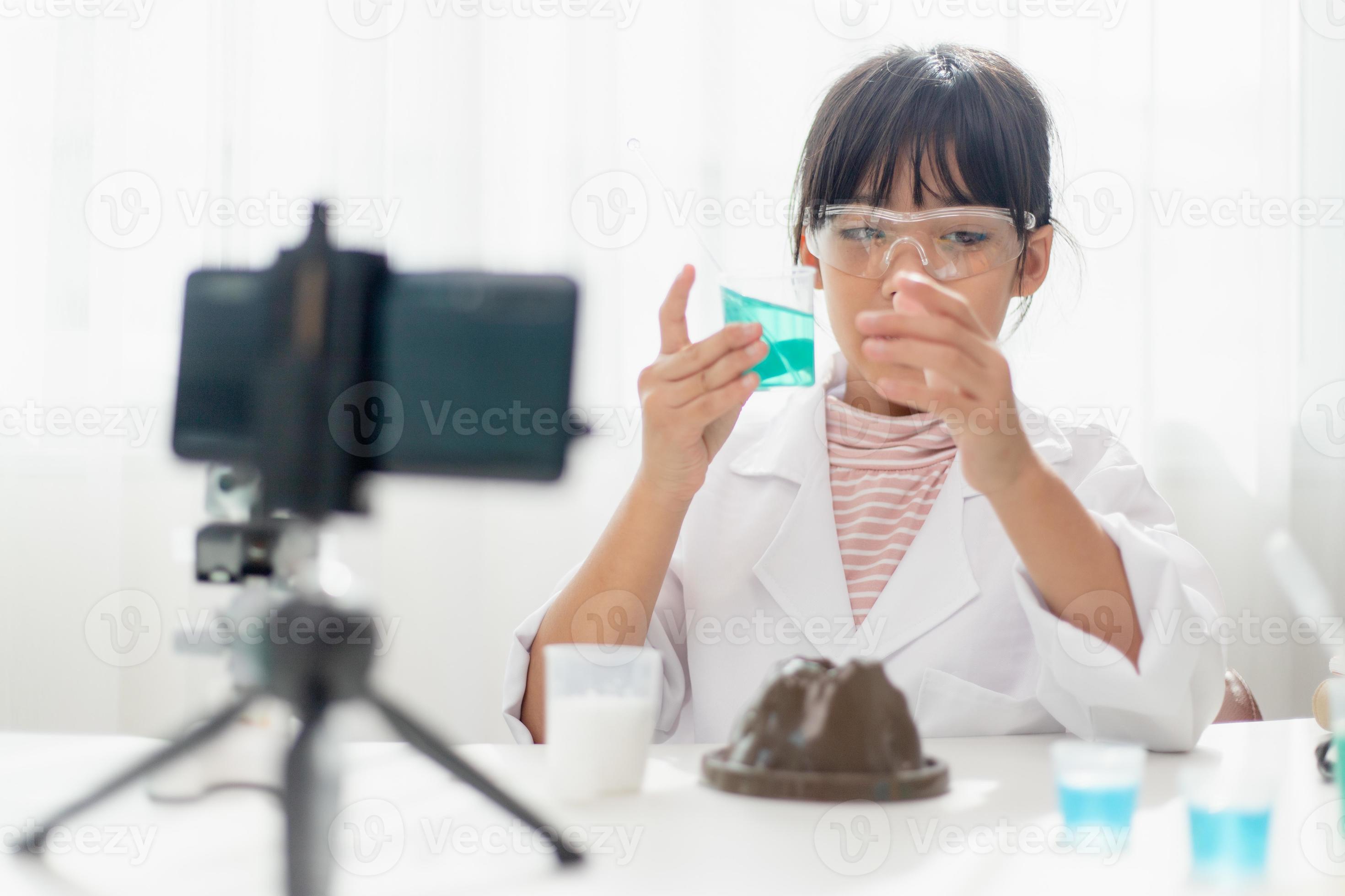 colegiala asiática haciendo experimentos de química fáciles y grabando un video para sus ...