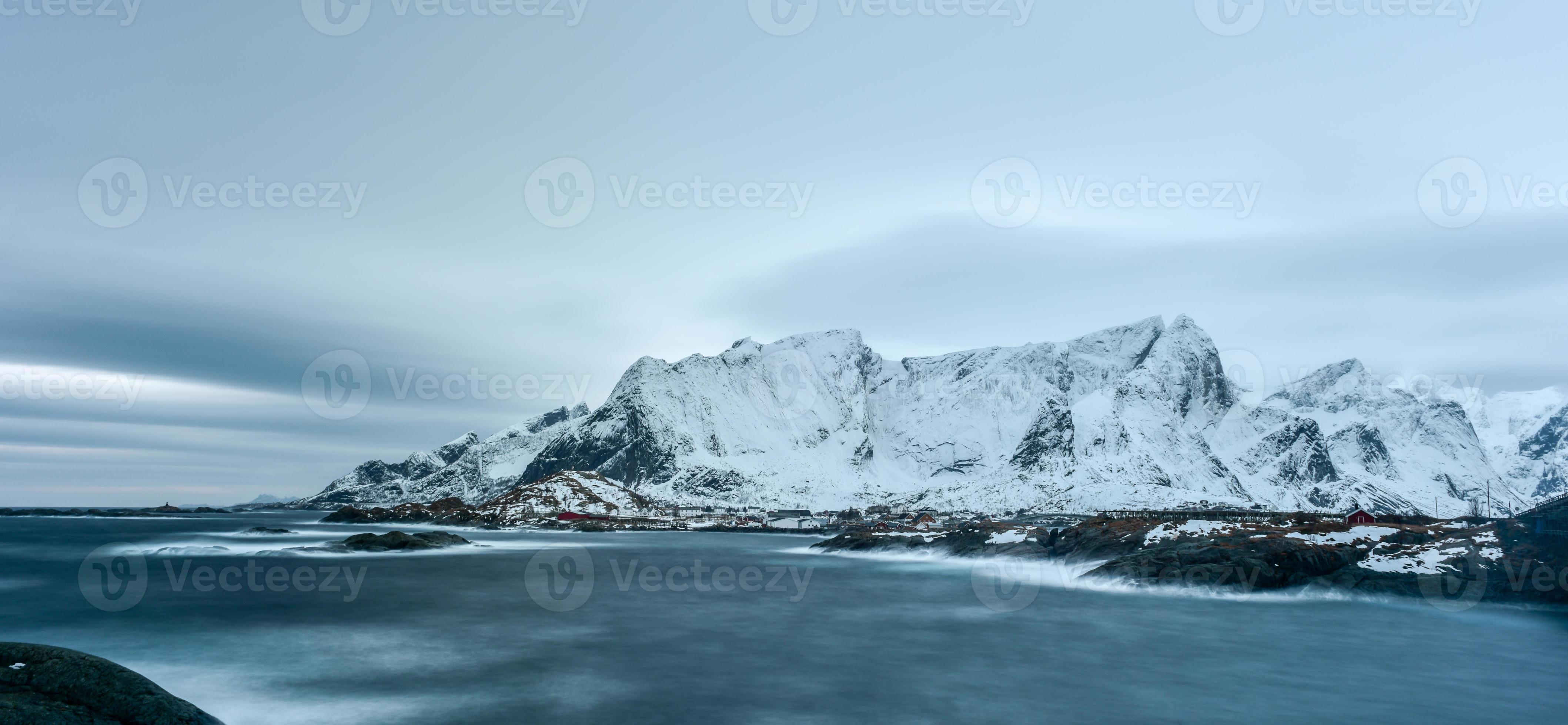 Fishing hut in the Hamnoy and Lilandstinden mountain peak in winter in Reine, Lofoten Islands ...