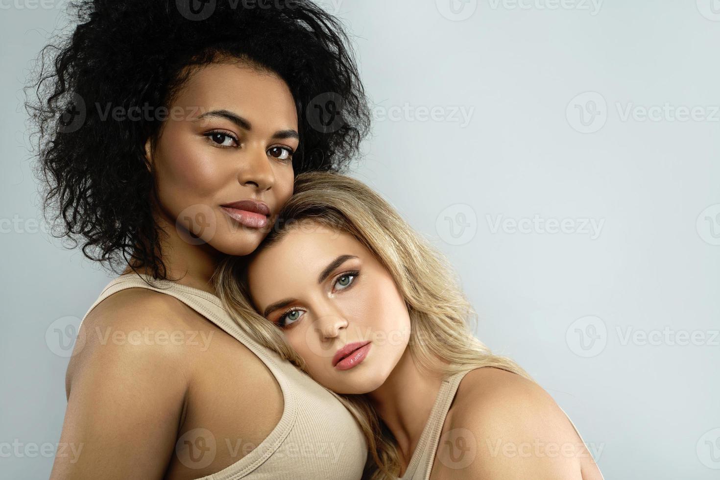 Portrait Of Caucasian And African American Women On Gray Background