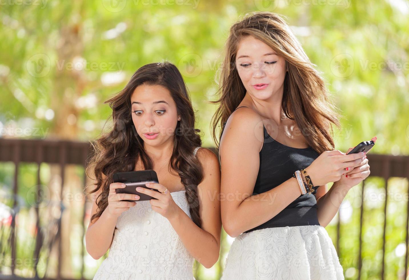 Two Expressive Mixed Race Girlfriends Using Their Smart Cell Phones