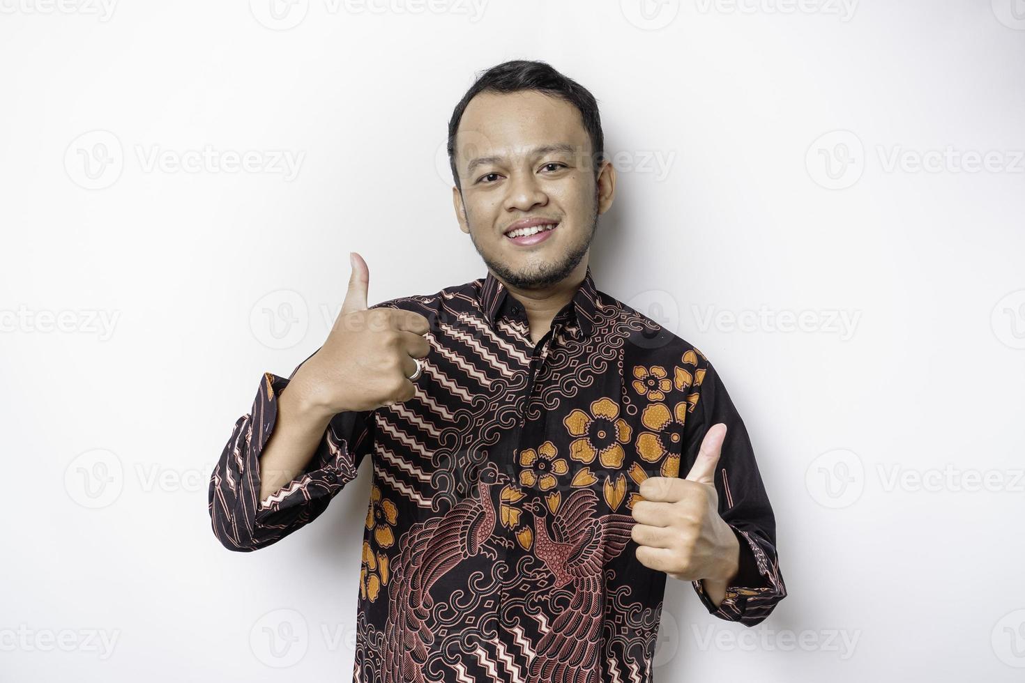 Excited Asian man wears batik shirt, gives thumbs up hand gesture of ...