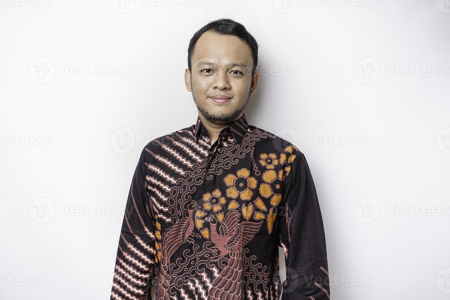 A portrait of a happy Asian man wearing batik shirt is smiling isolated ...