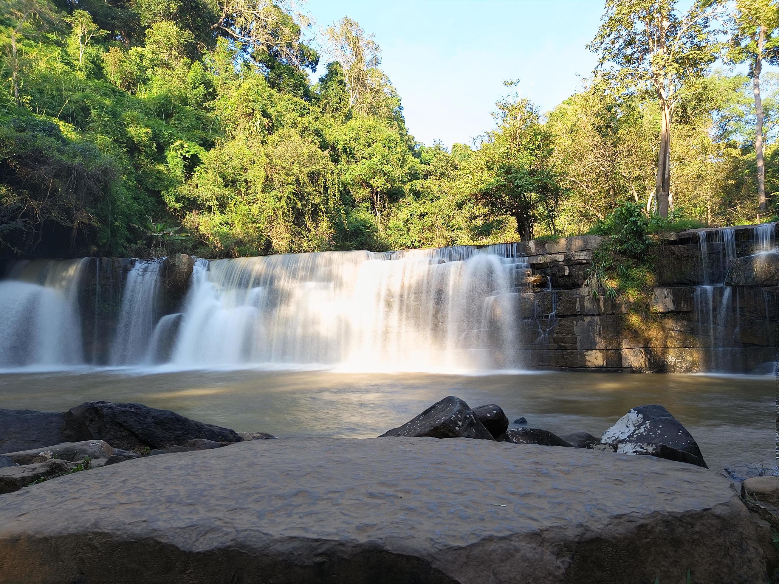 Front view, Sri Dit Waterfall is a small and forested one-level waterfall with sunlight at Khao ...