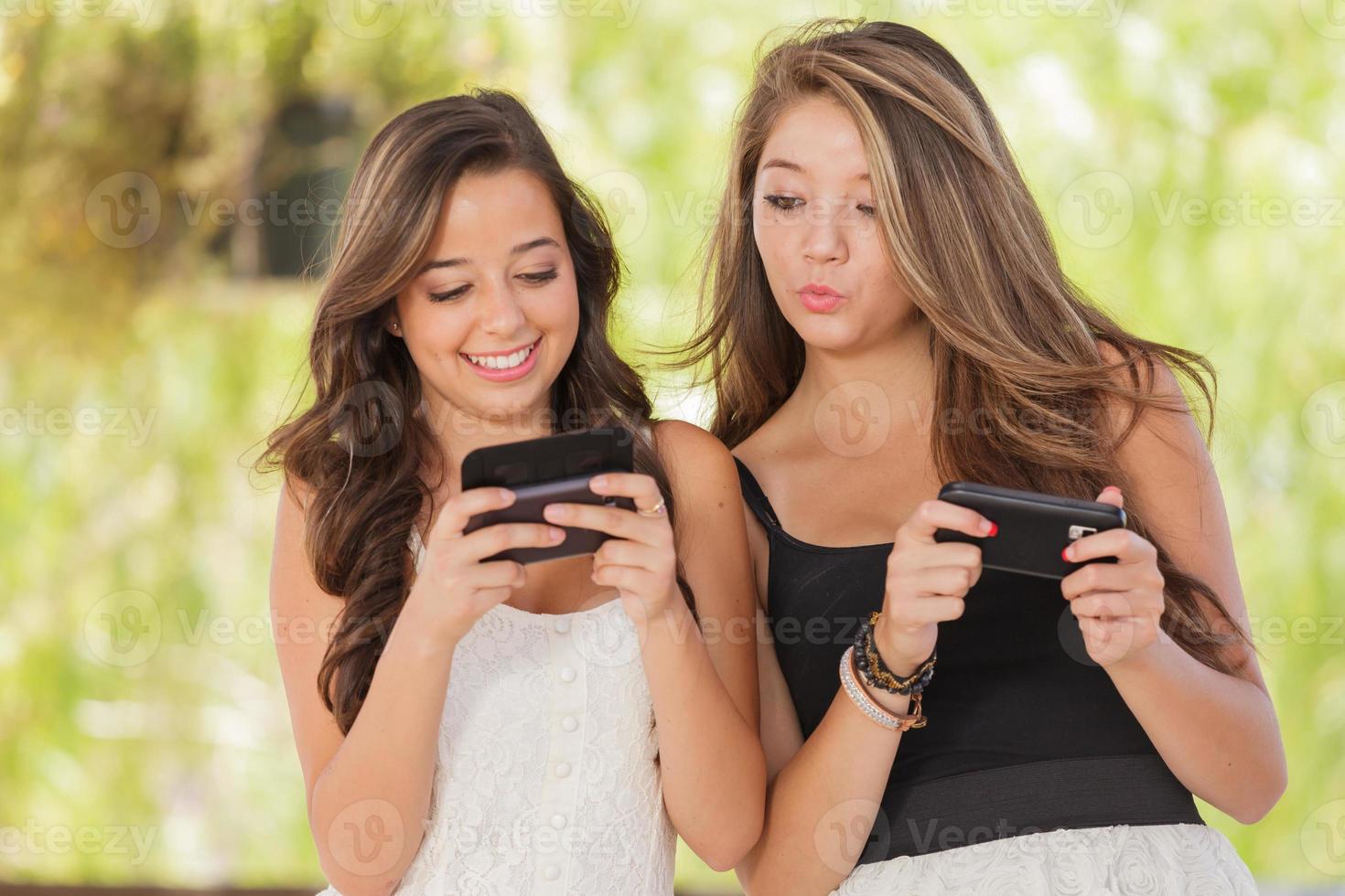 Two Expressive Mixed Race Girlfriends Using Their Smart Cell Phones