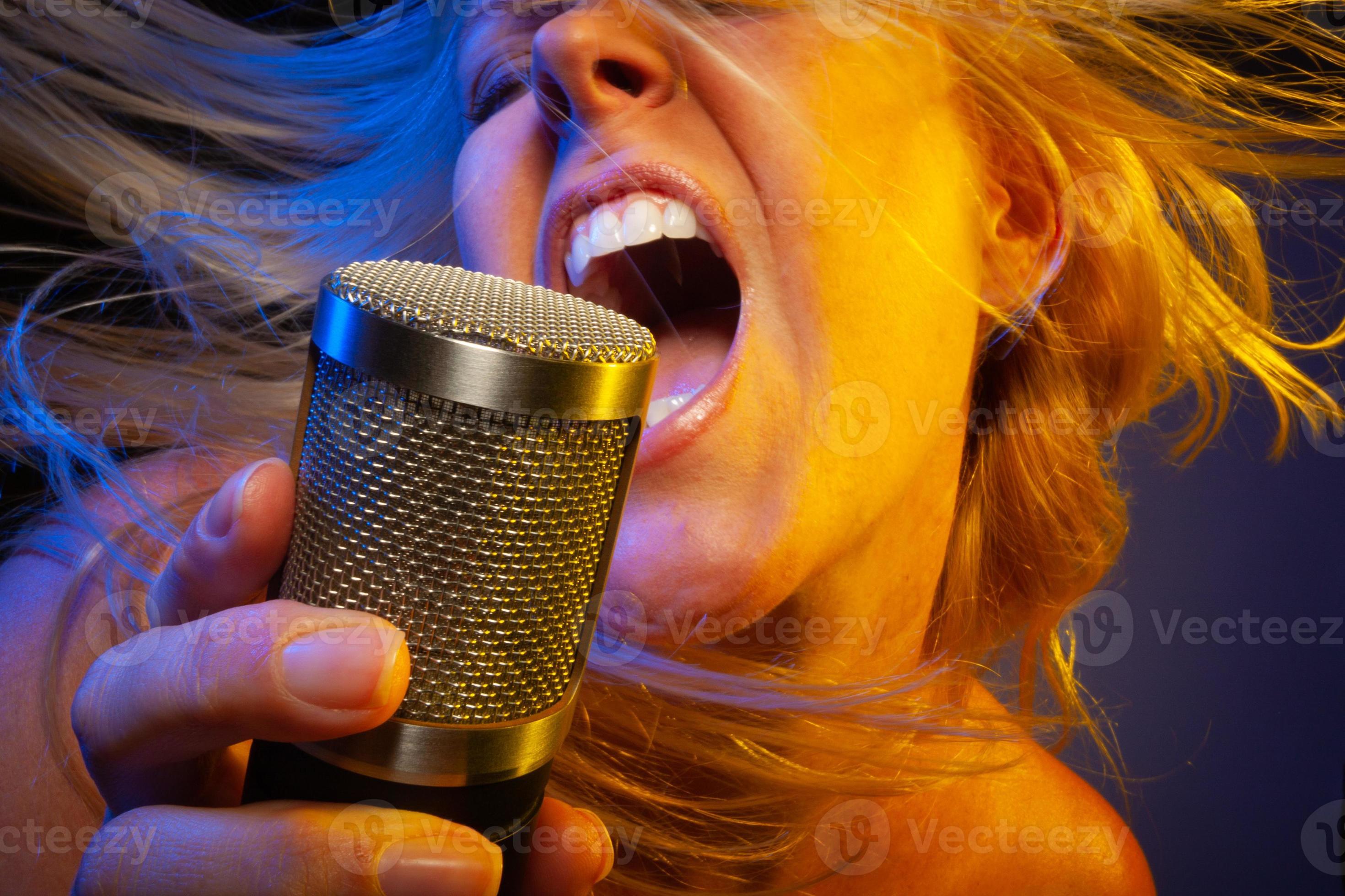 Female Vocalist Under Gelled Lighting Sings With Passion Into Condenser female-vocalist-under-gelled-lighting-sings-with-passion-into-condenser