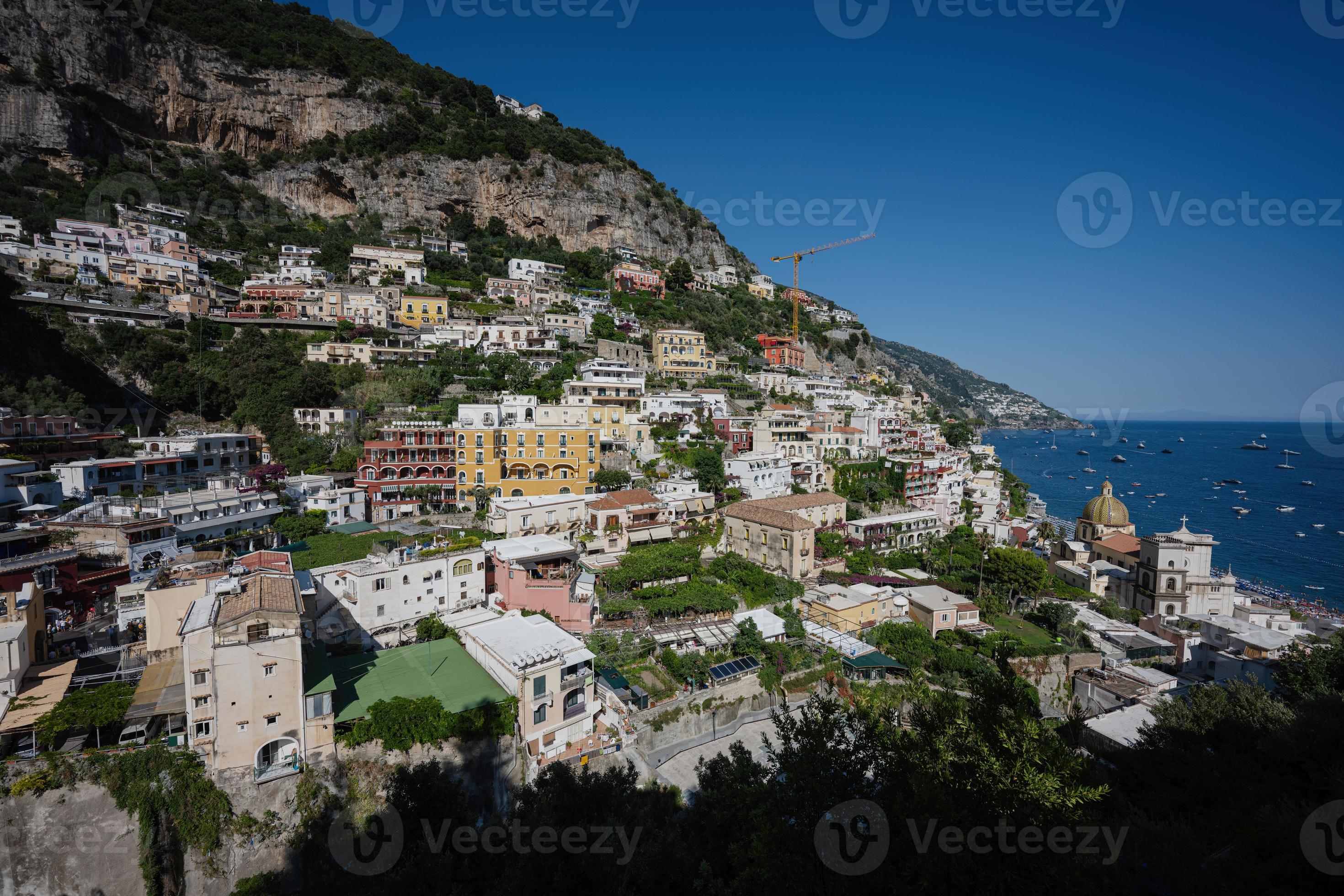 Positano with hotels and houses on hills leading down to coast, comfortable beaches and azure ...