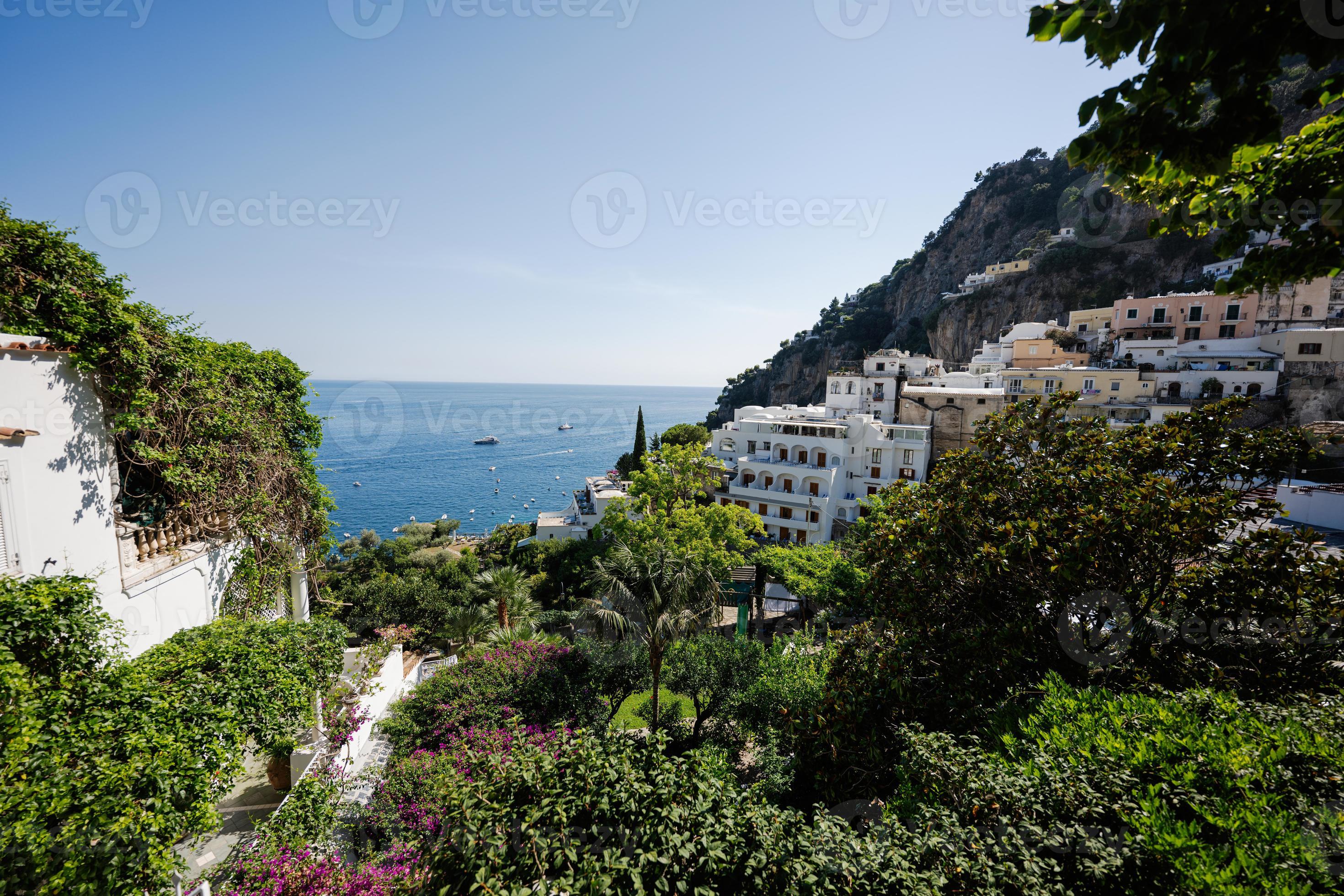 Positano with hotels and houses on hills leading down to coast, comfortable beaches and azure ...