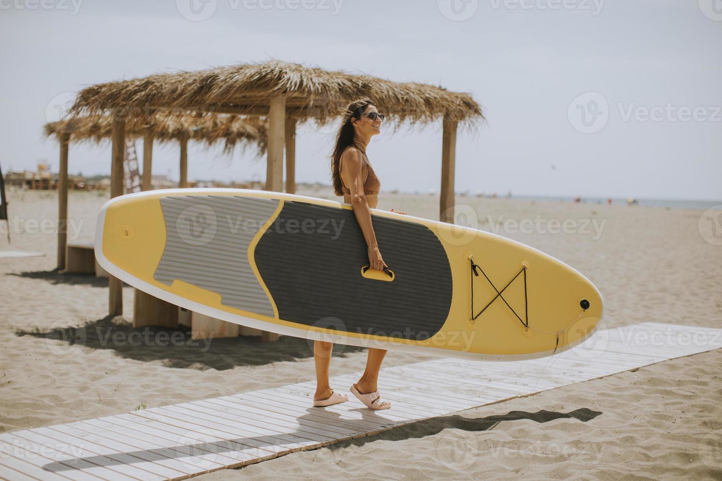 Young woman with paddle board on the beach on a summer day 16603280 ...