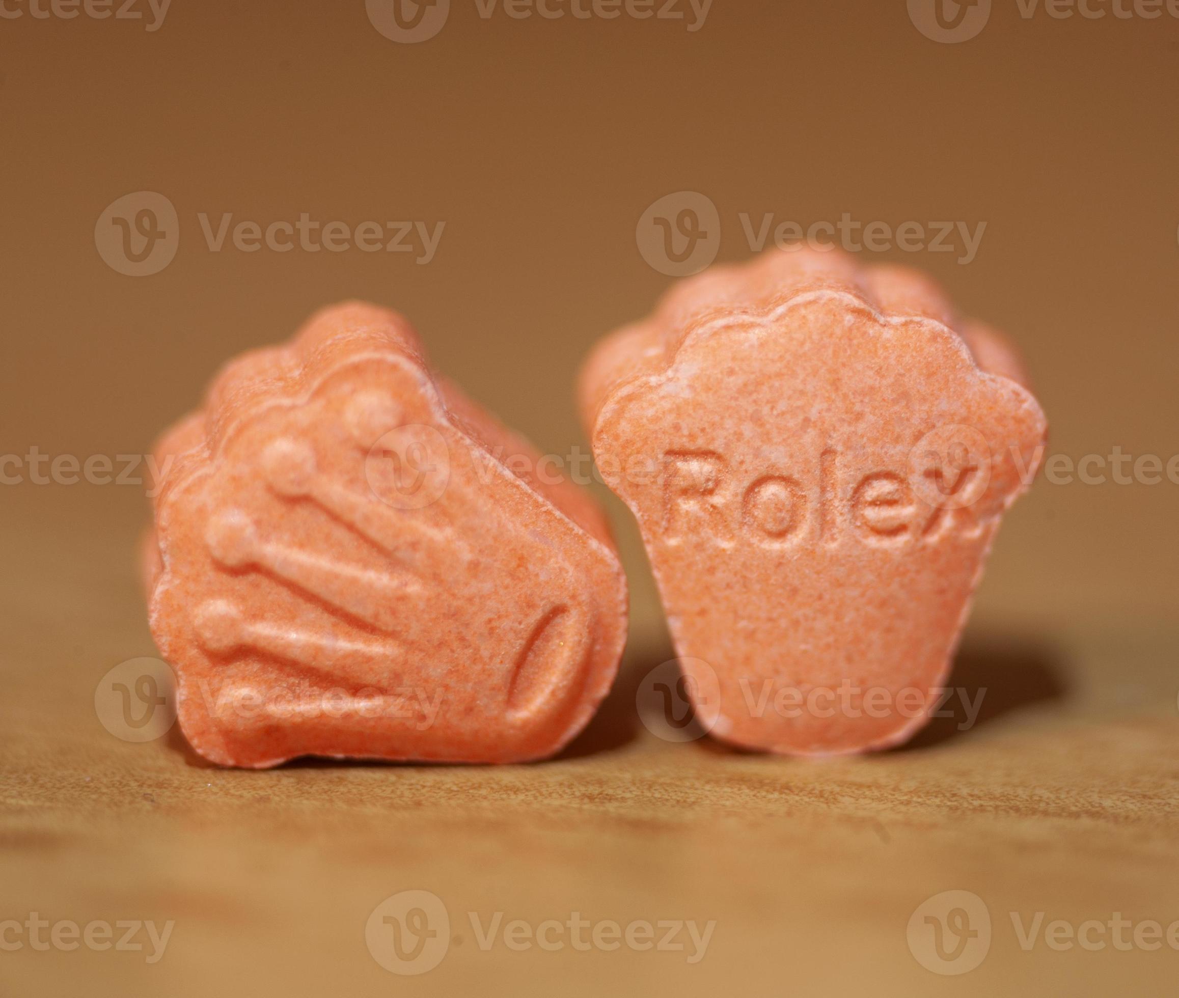 Orange pills with mdma ecstasy dope rolex drug close up background fine art in high quality ...